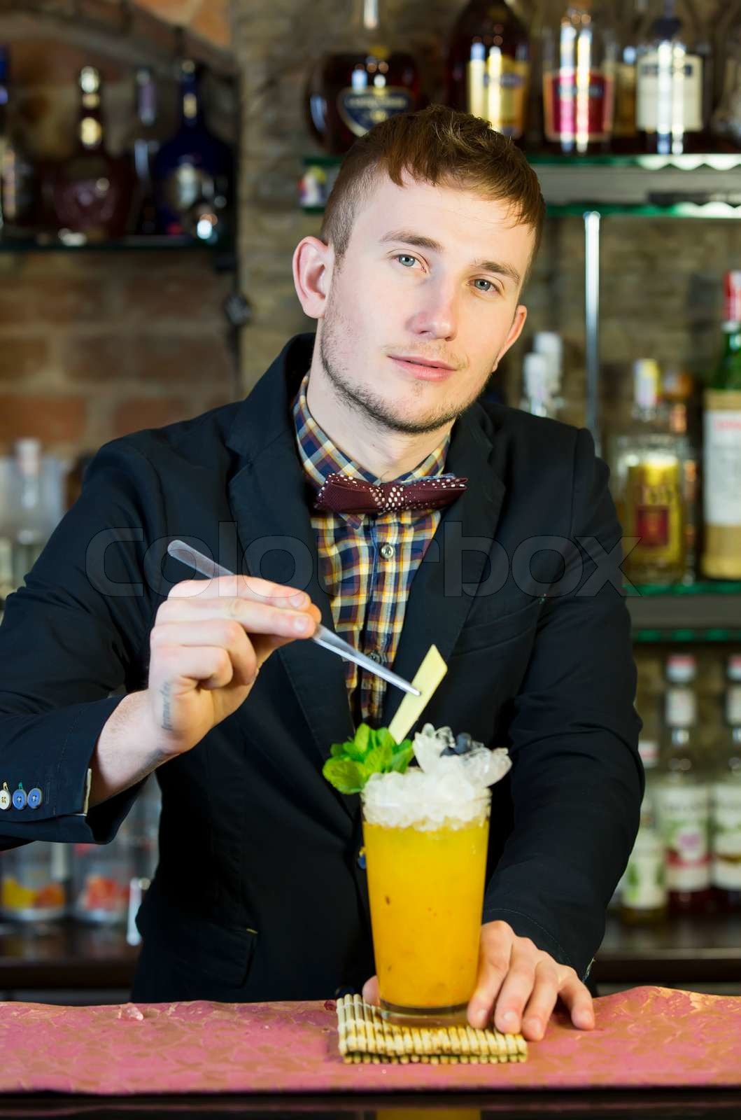 young man working as a bartender in a nightclub bar | Stock image ...
