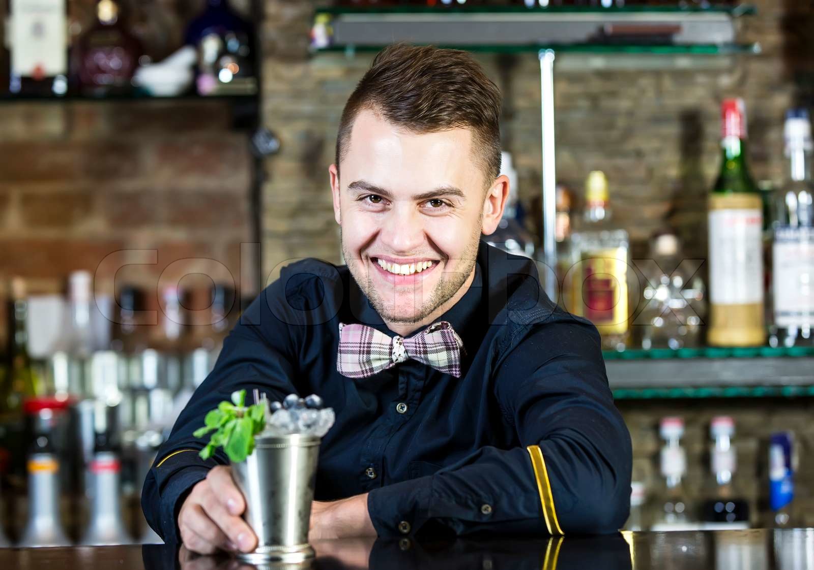 young man working as a bartender in a nightclub bar | Stock image ...