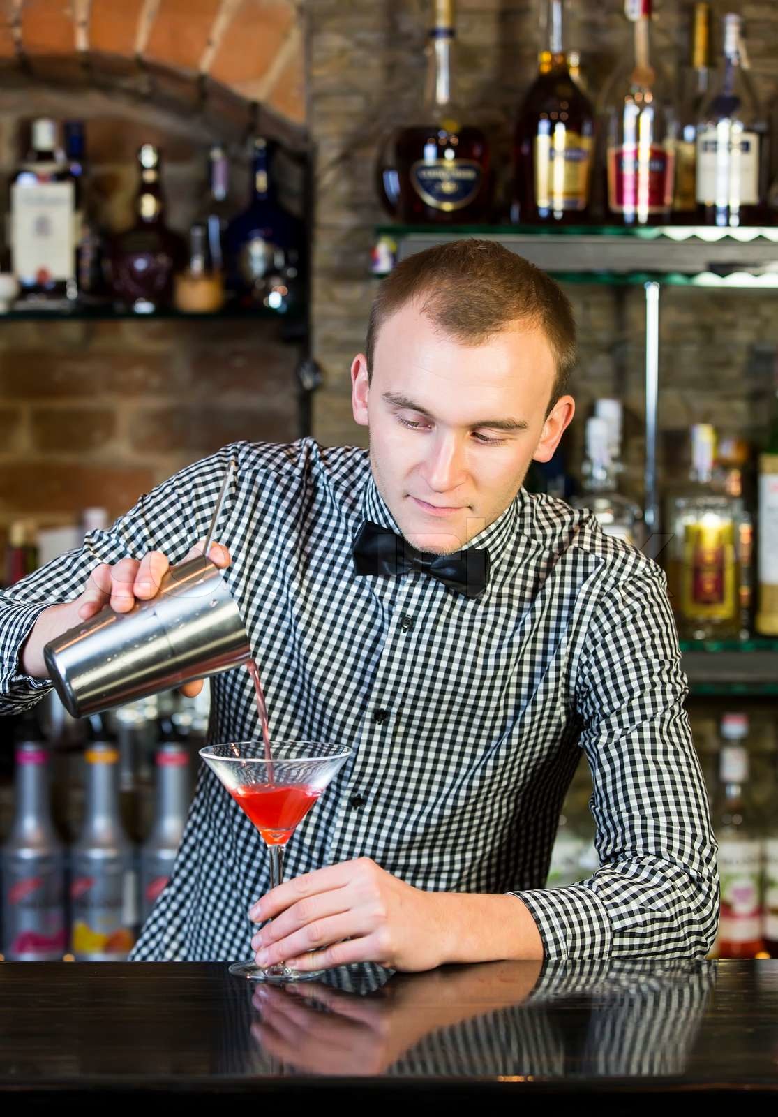 young man working as a bartender in a nightclub bar | Stock image ...