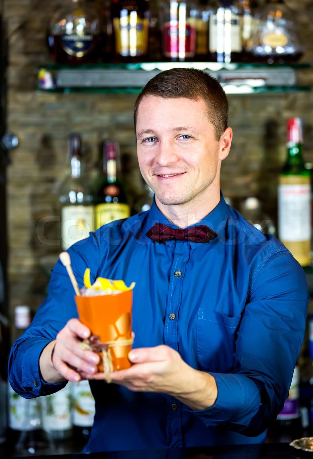 young man working as a bartender in a nightclub bar | Stock image ...
