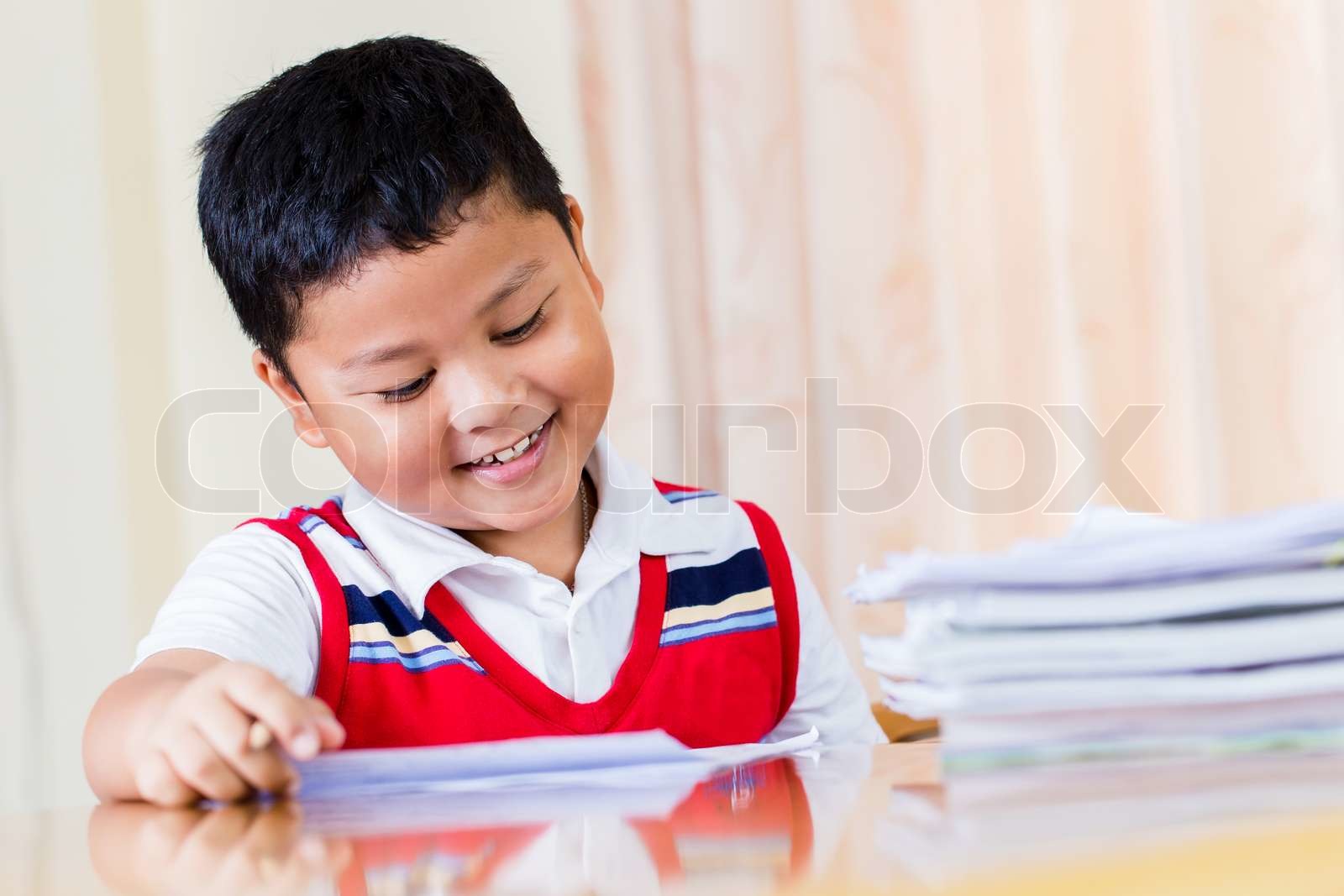 The boy work homework carefully. | Stock image | Colourbox