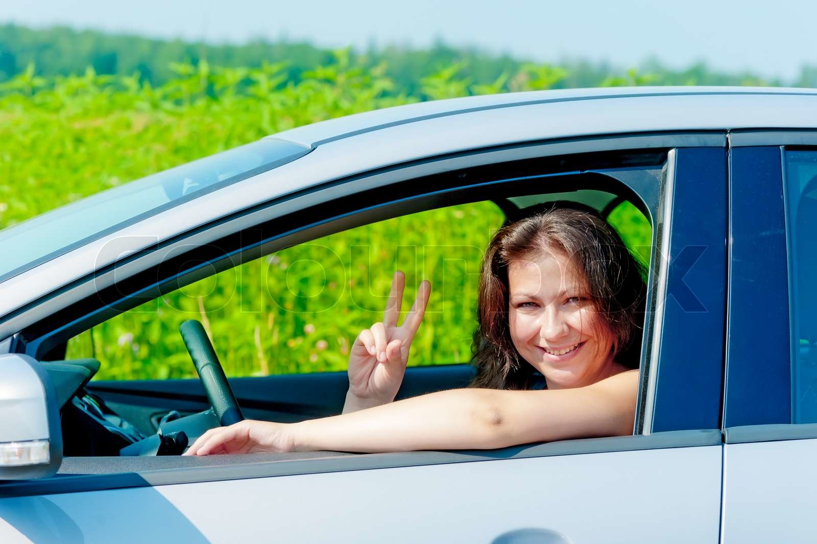 smiling girl driving a car on nature | Stock image | Colourbox