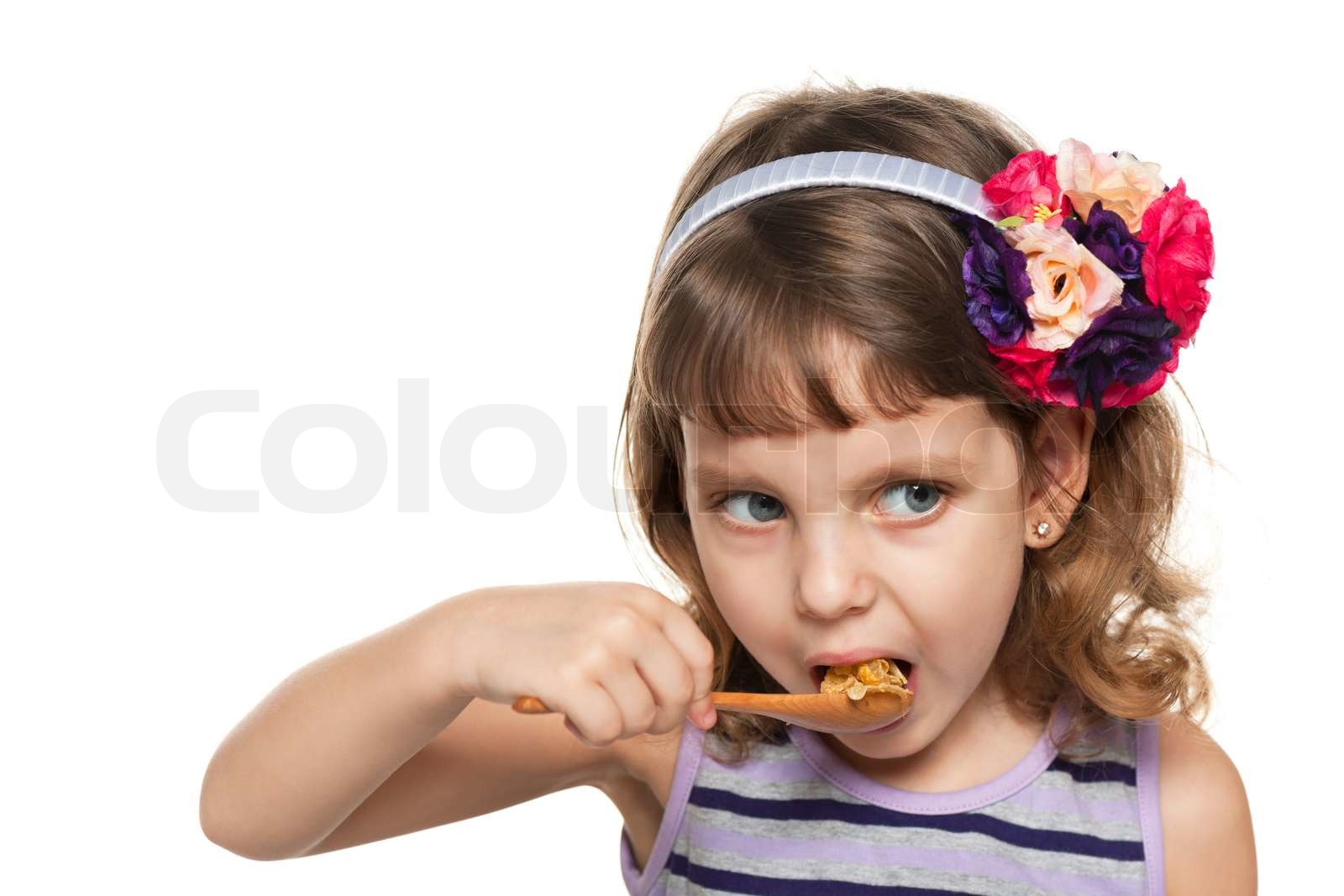 Small girl eats with a spoon | Stock image | Colourbox