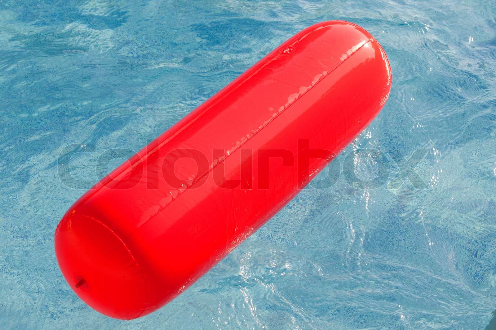 Red float floating in the pool | Stock image | Colourbox