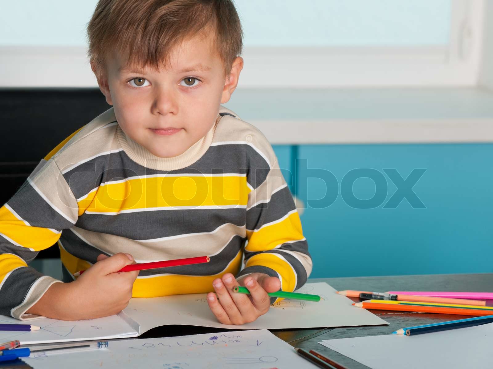 Serious little boy at the desk | Stock image | Colourbox