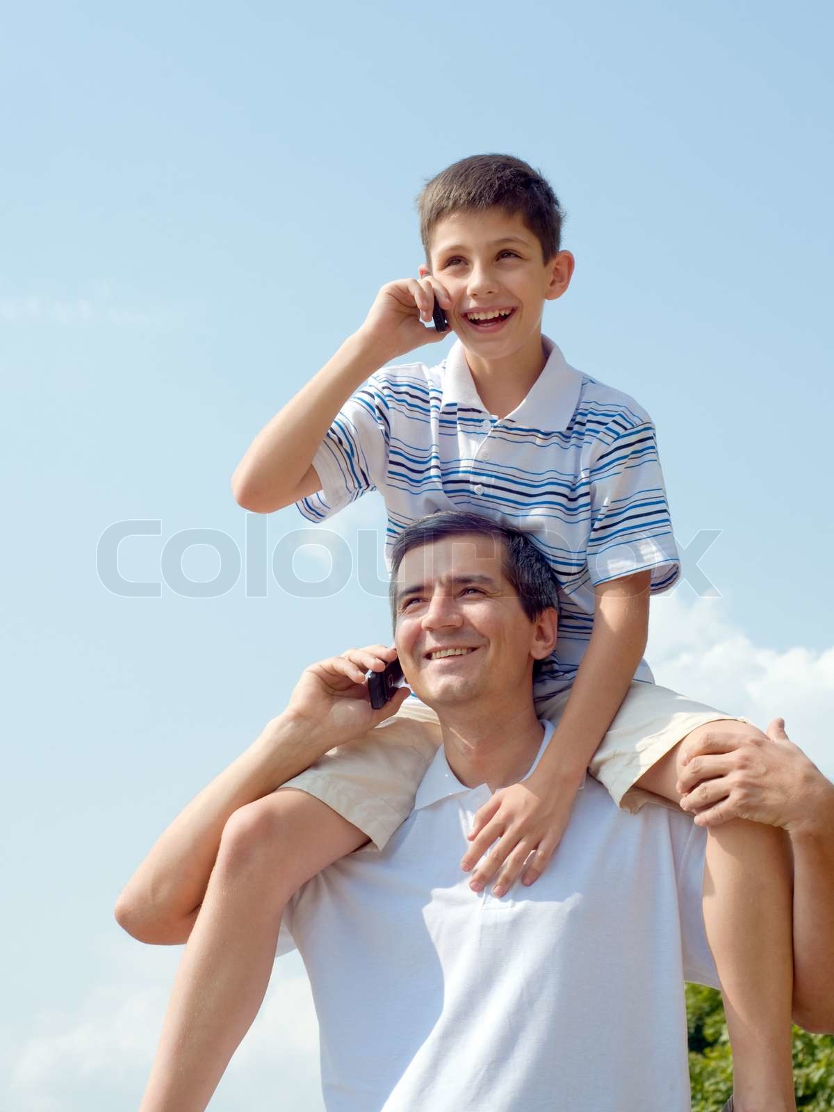 father and his son are speaking over mobiles | Stock image | Colourbox