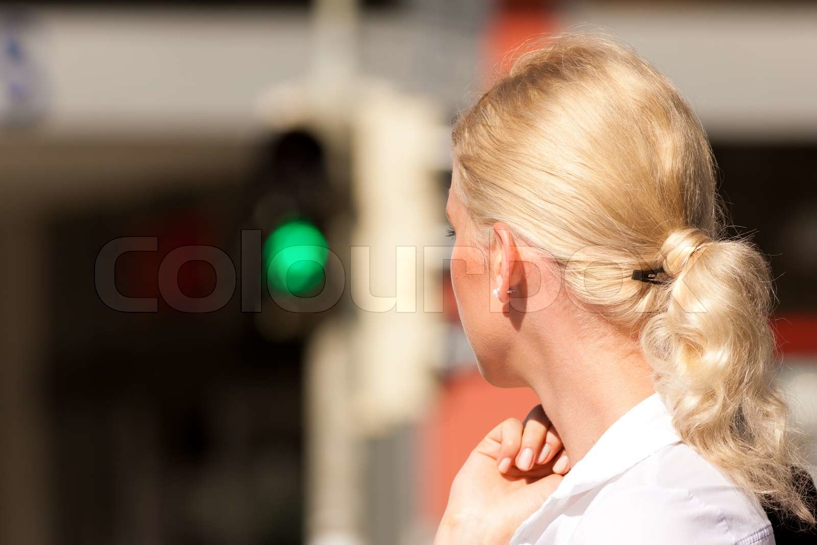 Woman standing at green traffic light | Stock image | Colourbox