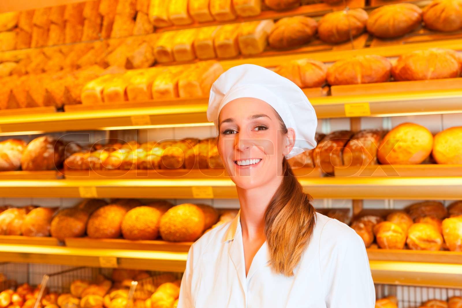 Female baker selling bread in bakery | Stock image | Colourbox