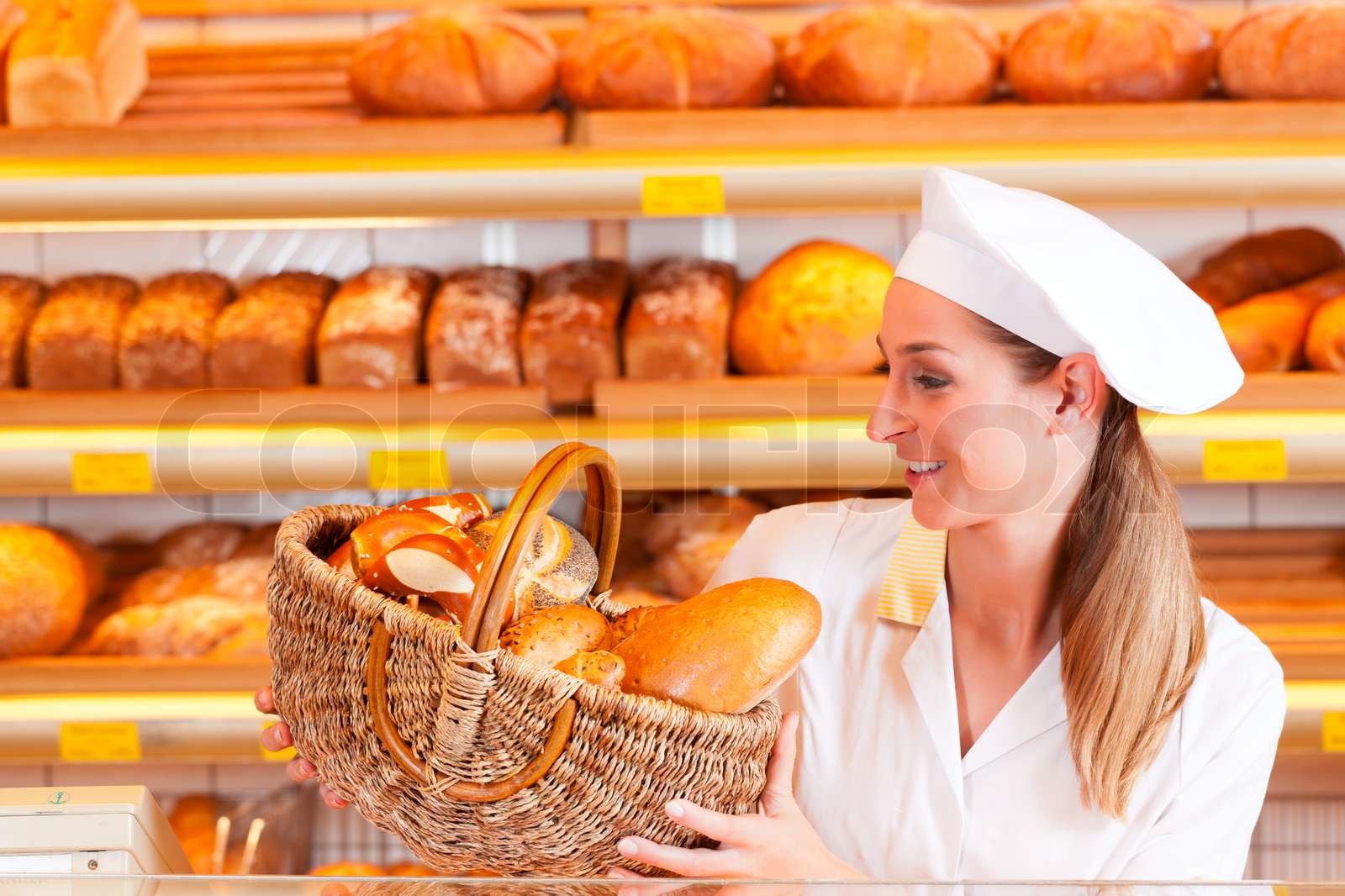 Female baker selling bread in her bakery | Stock image | Colourbox