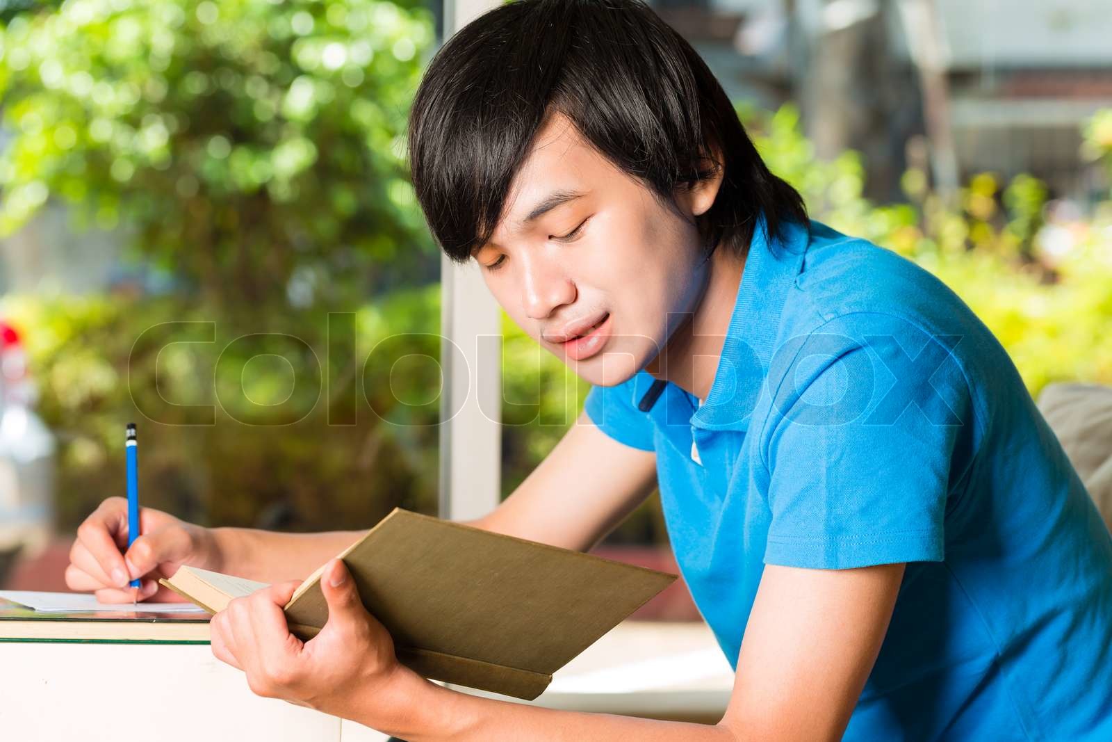 Asian student reading book or textbook learning | Stock image | Colourbox