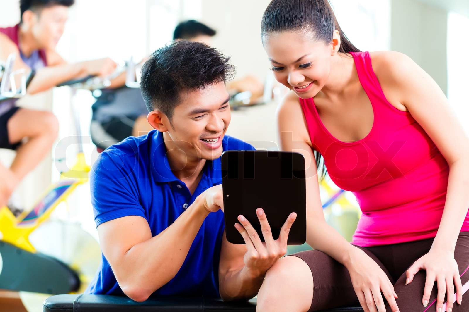 Asian personal trainer with woman in fitness gym | Stock image | Colourbox