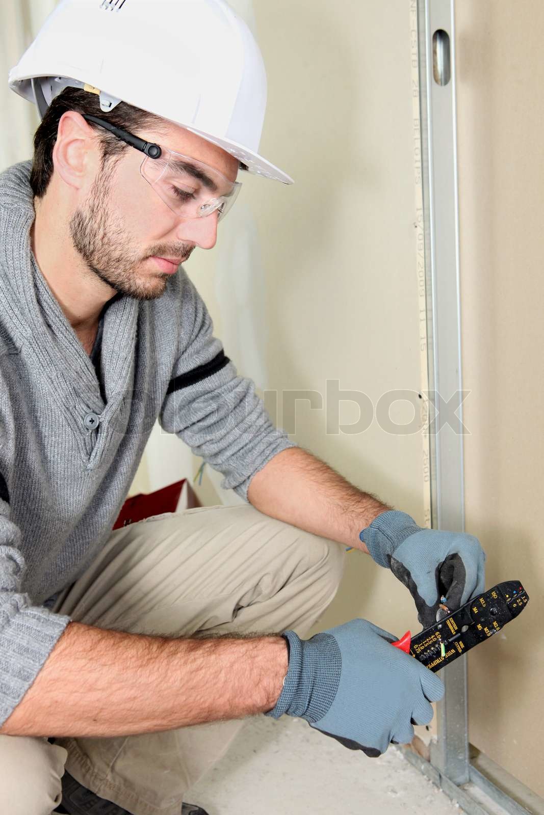 Man cutting electrical wire | Stock image | Colourbox