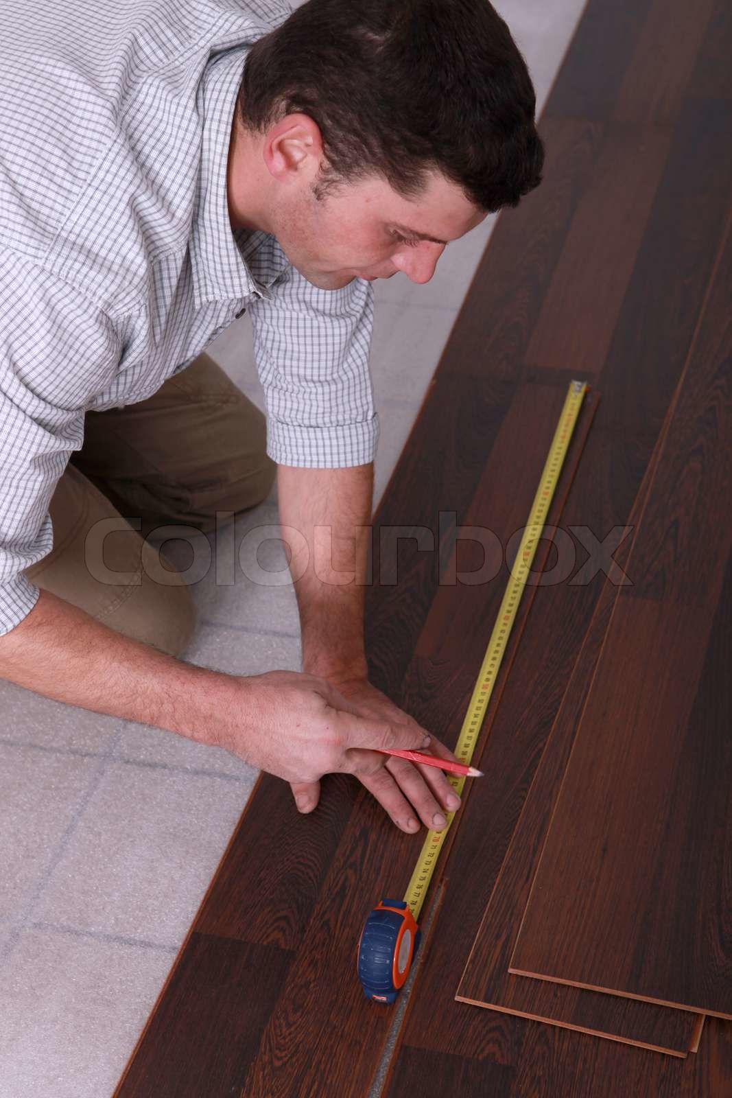 Man measuring flooring | Stock image | Colourbox