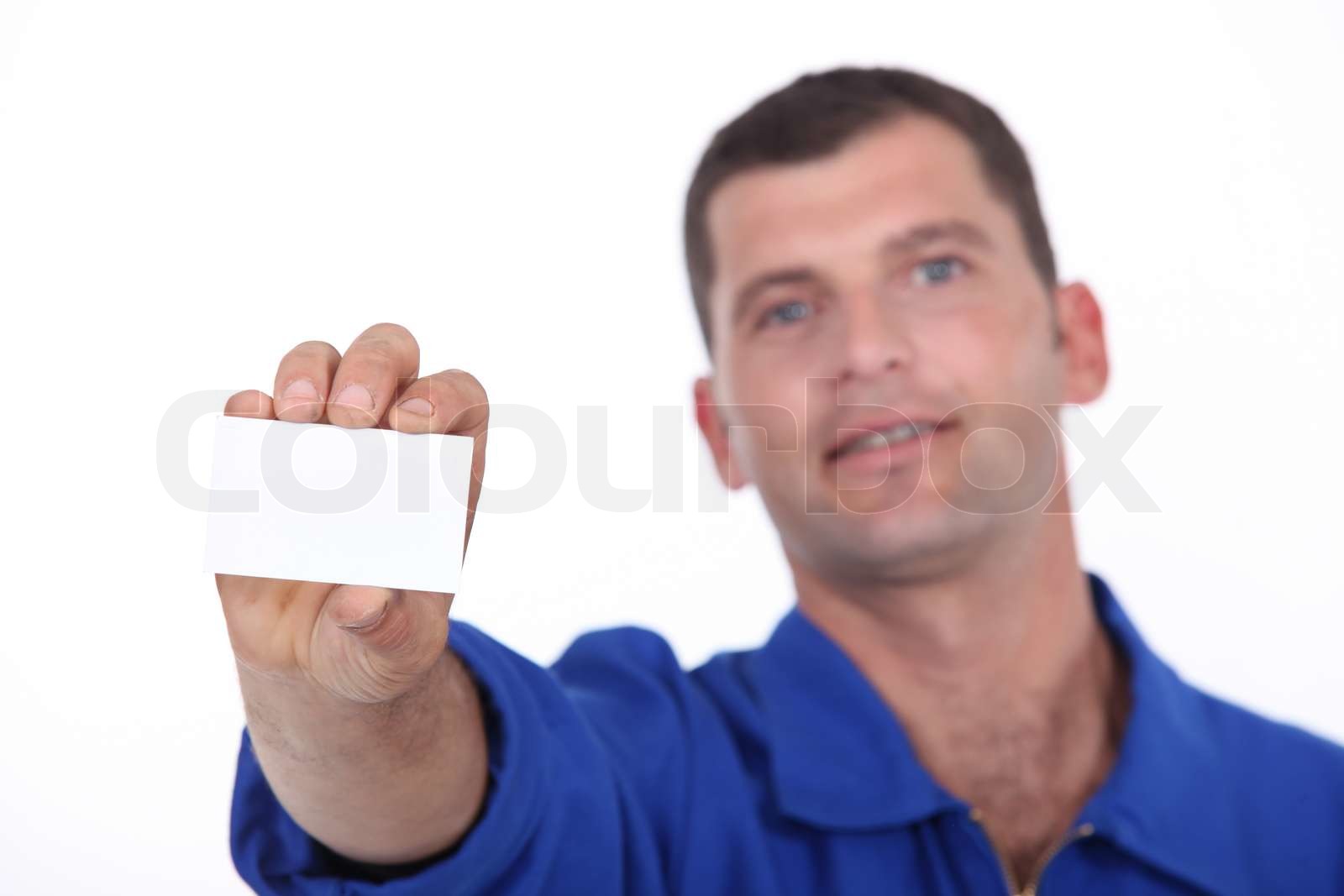 Man in blue overalls holding up a blank business card | Stock image ...
