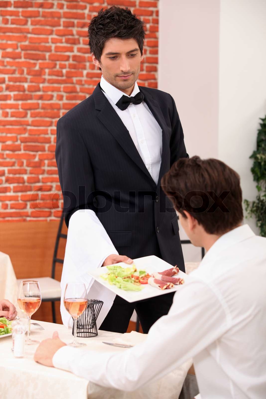 Waiter serving a meal | Stock image | Colourbox