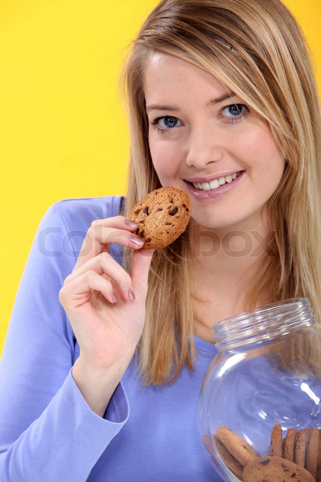 Woman eating a cookie | Stock image | Colourbox