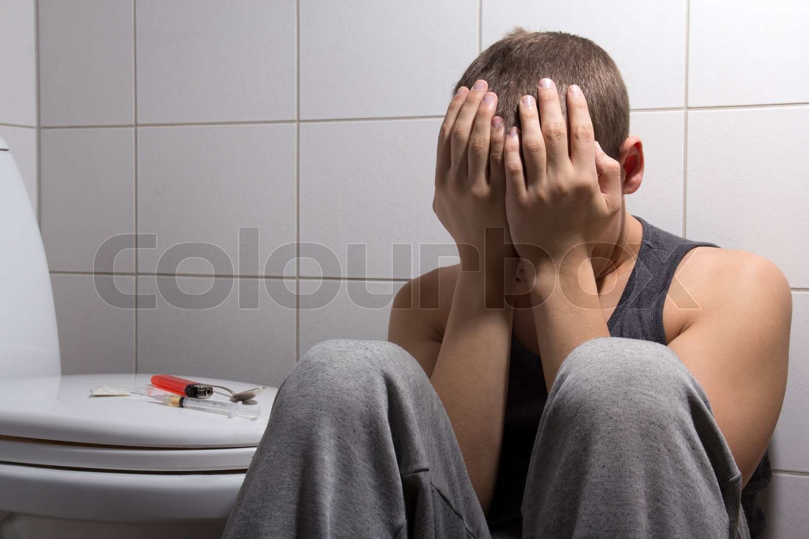 stoned man with heroin addiction sitting in bathroom | Stock image ...