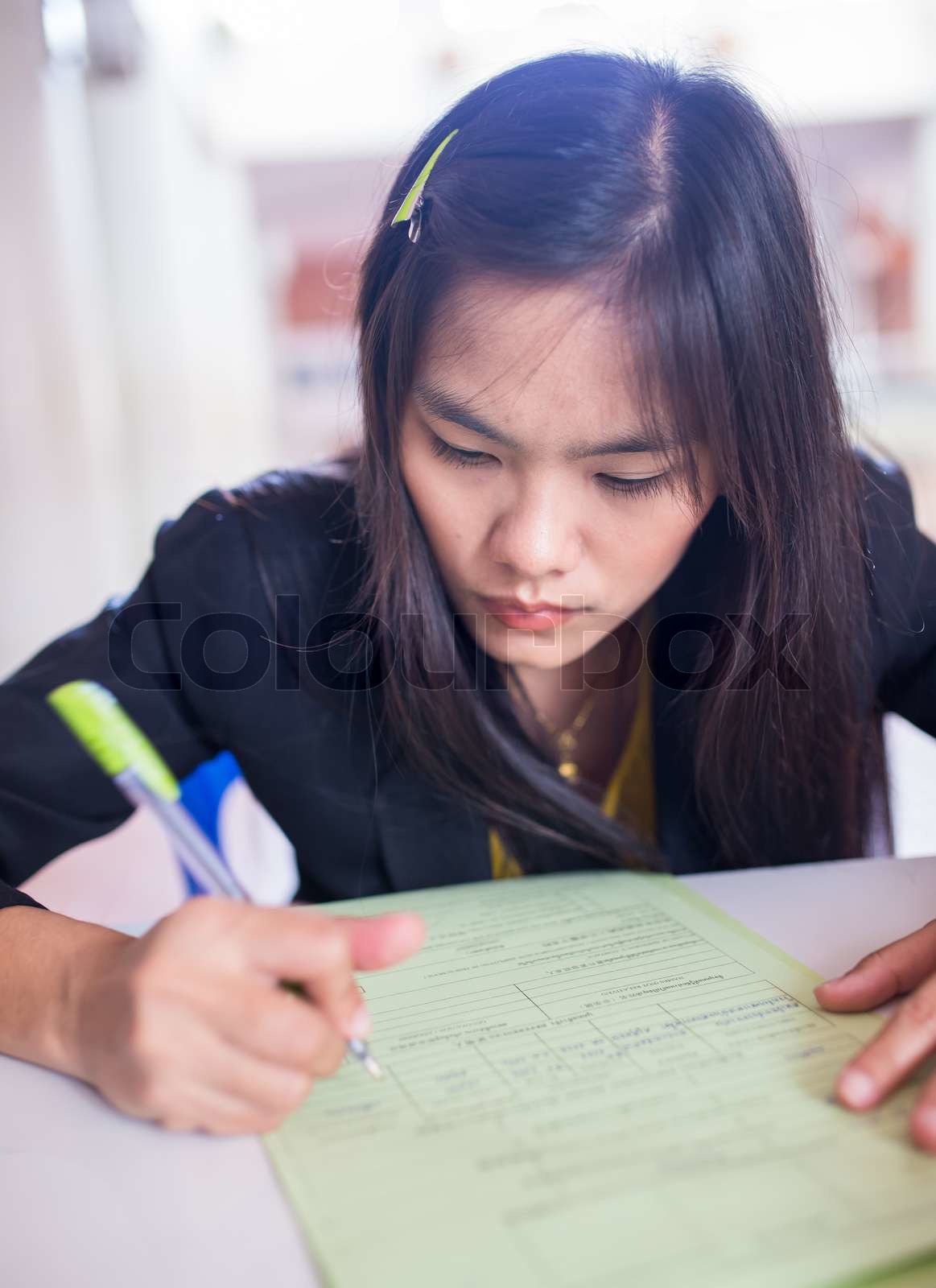 Asian girls are signing documents | Stock image | Colourbox