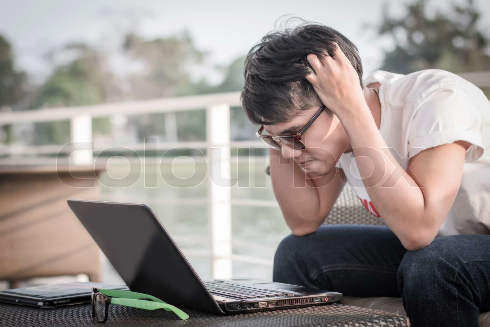 Asian men using computers, are stressed | Stock image | Colourbox