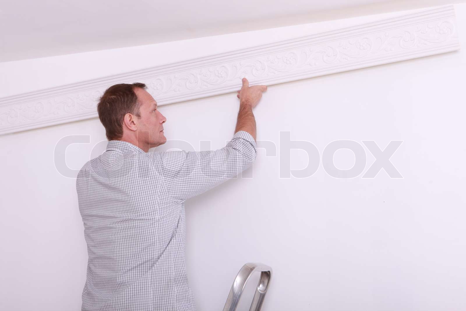 man fixing something on a wall | Stock image | Colourbox