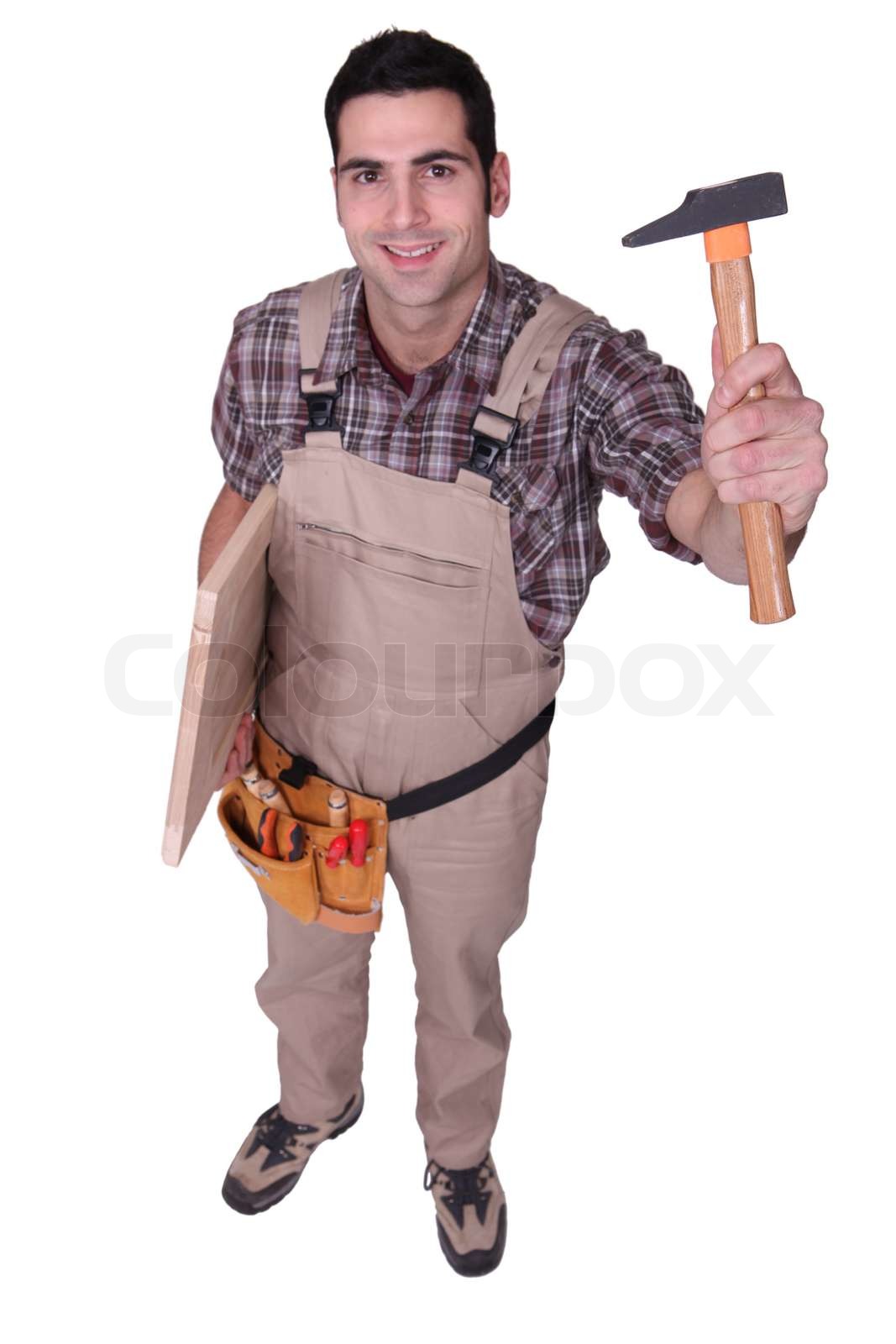Tradesman holding up a tool | Stock image | Colourbox