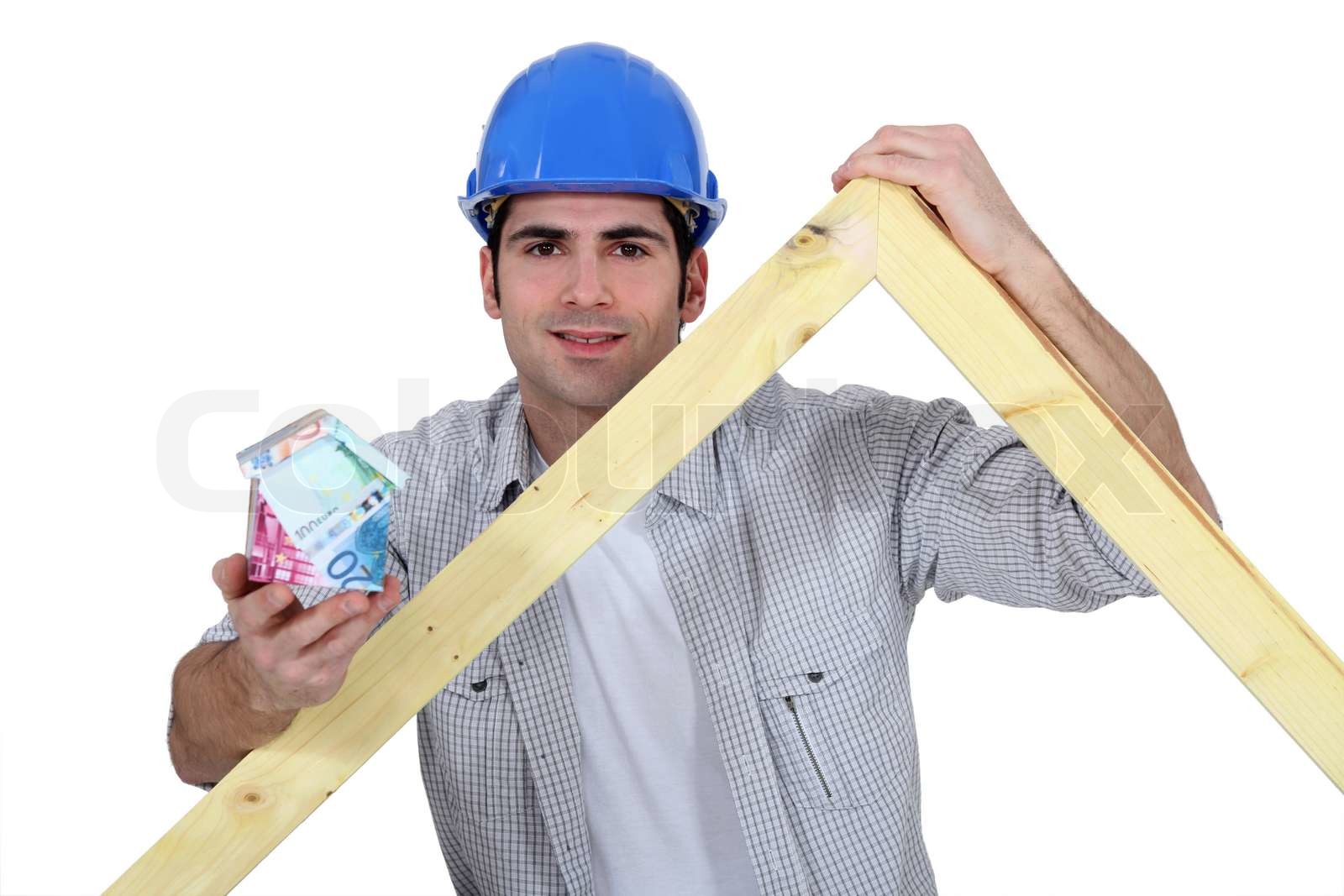 Carpenter stood with wooden truss and money | Stock image | Colourbox