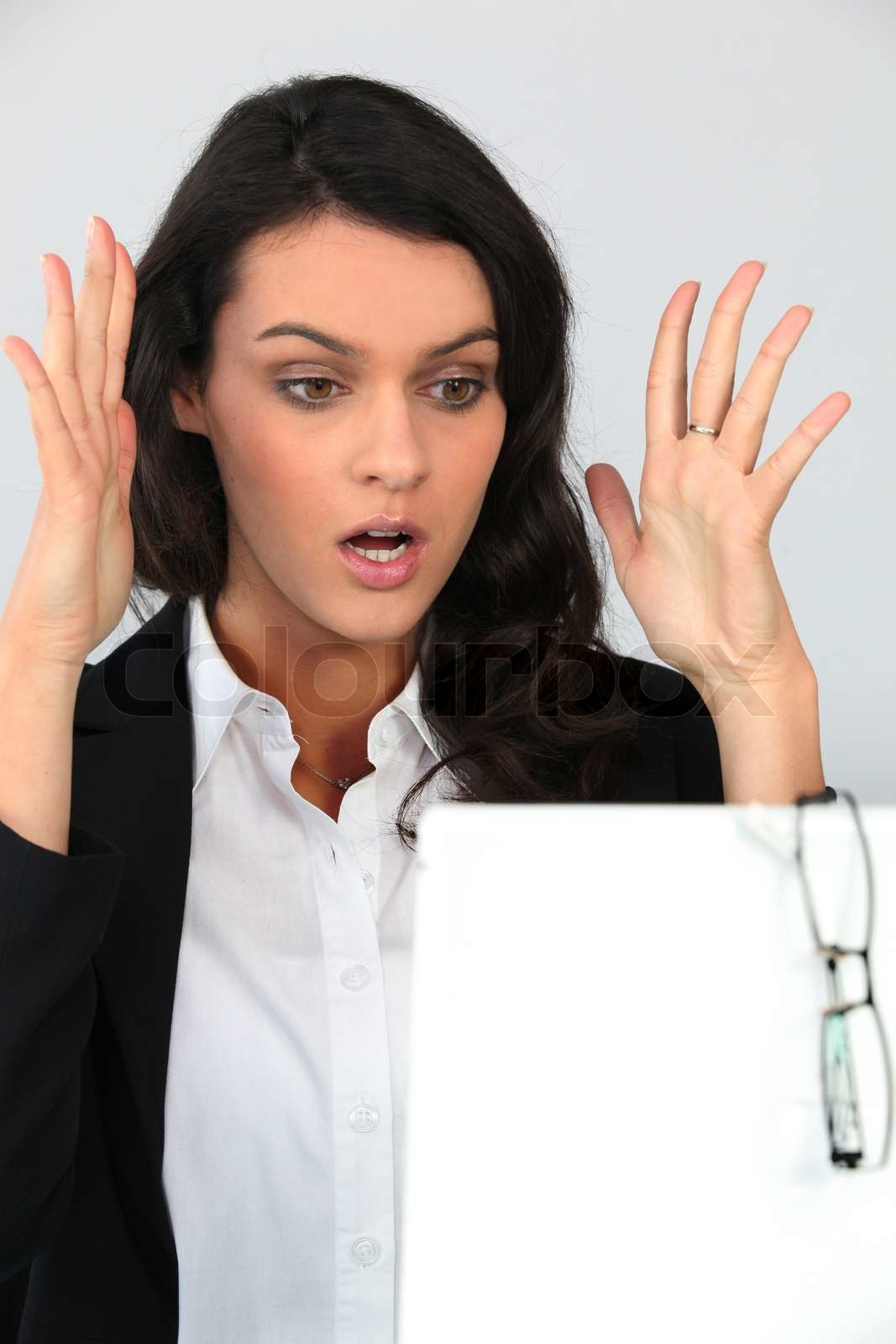 Woman holding her hands up in shock at a board left blank for your ...