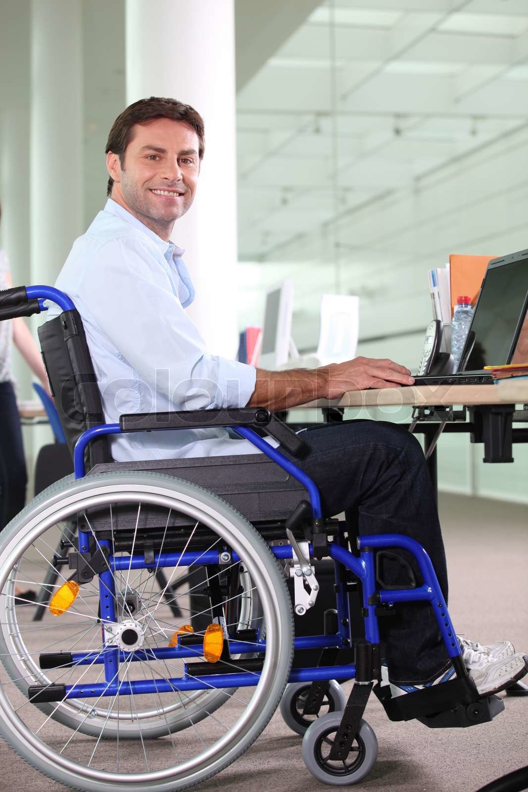 Disabled office worker using a laptop | Stock image | Colourbox