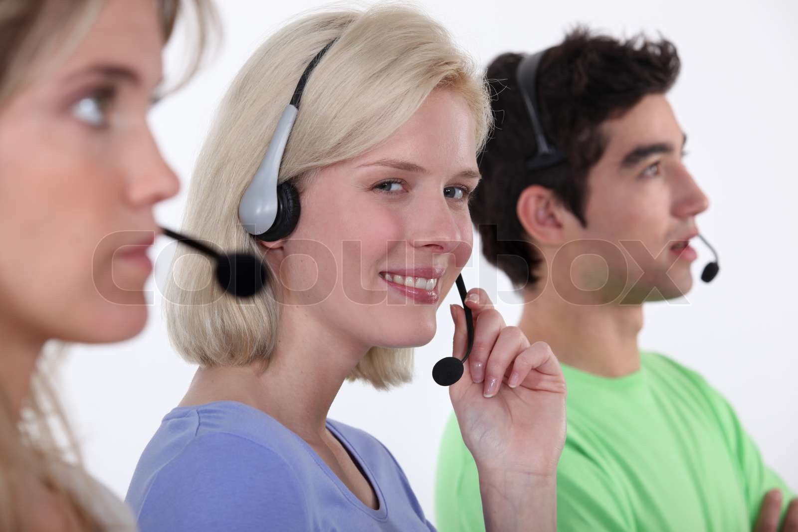 Three call-center workers sat in a row | Stock image | Colourbox