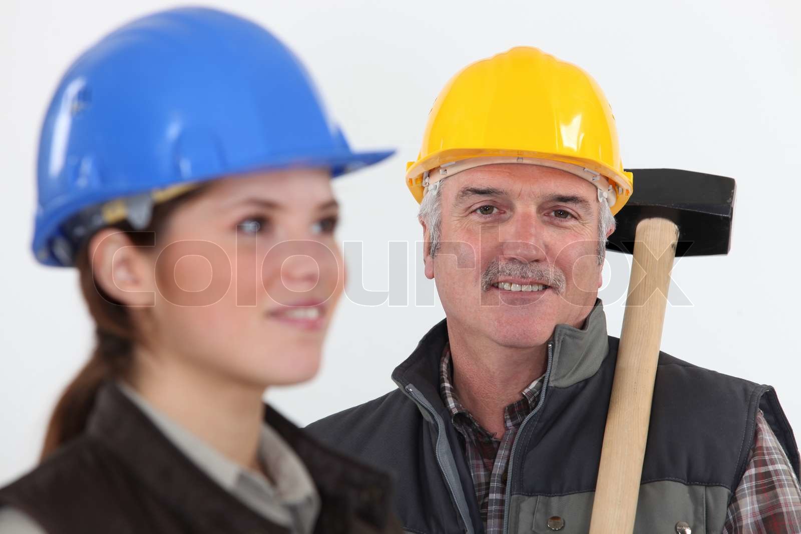 Construction worker with young female helper | Stock image | Colourbox
