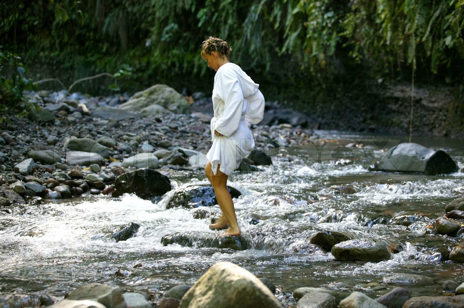 Woman walking in a stream | Stock image | Colourbox