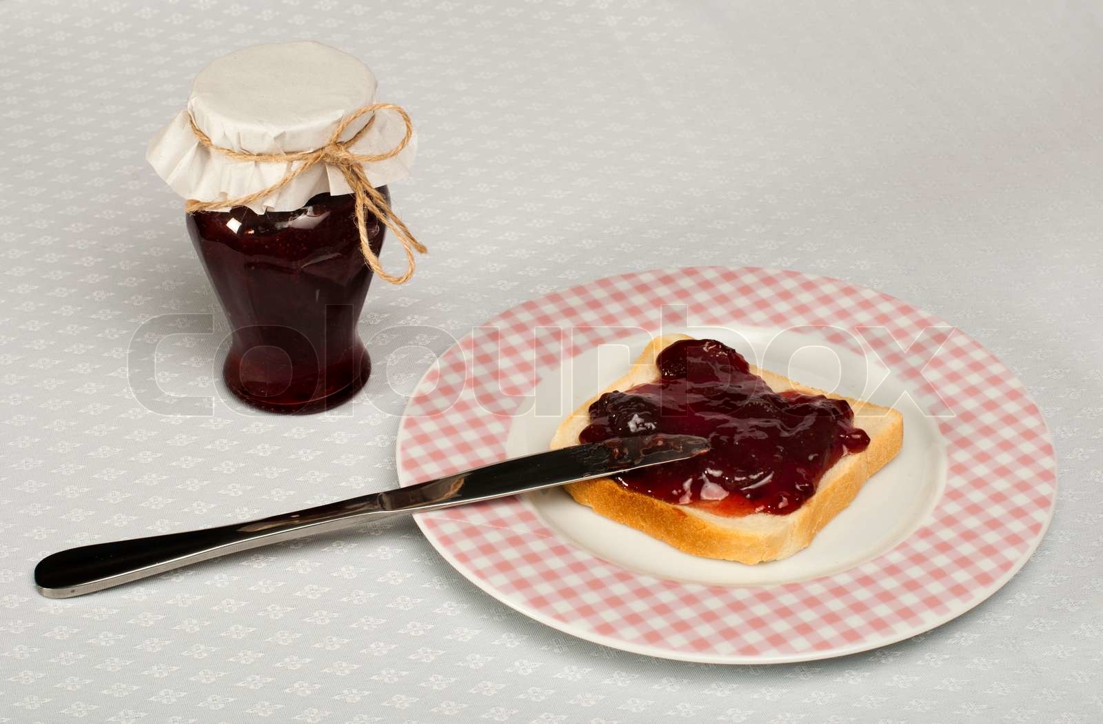 Spread jam on bread | Stock image | Colourbox