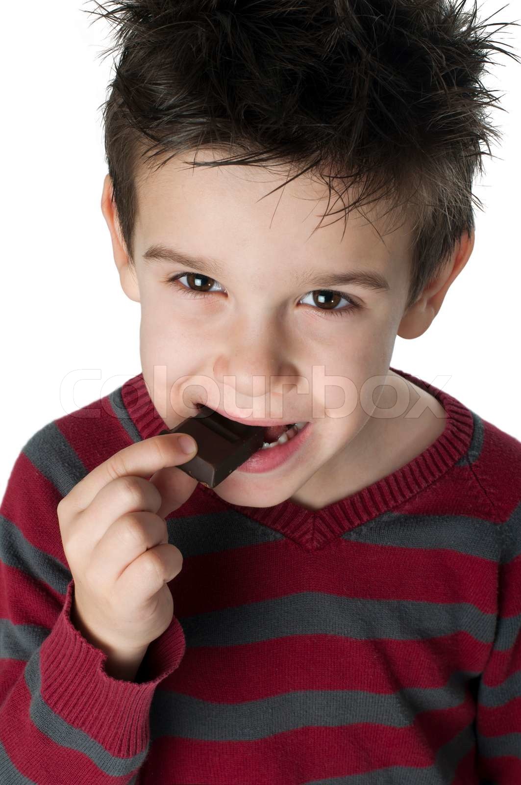 Smiling kid eating chocolate | Stock image | Colourbox