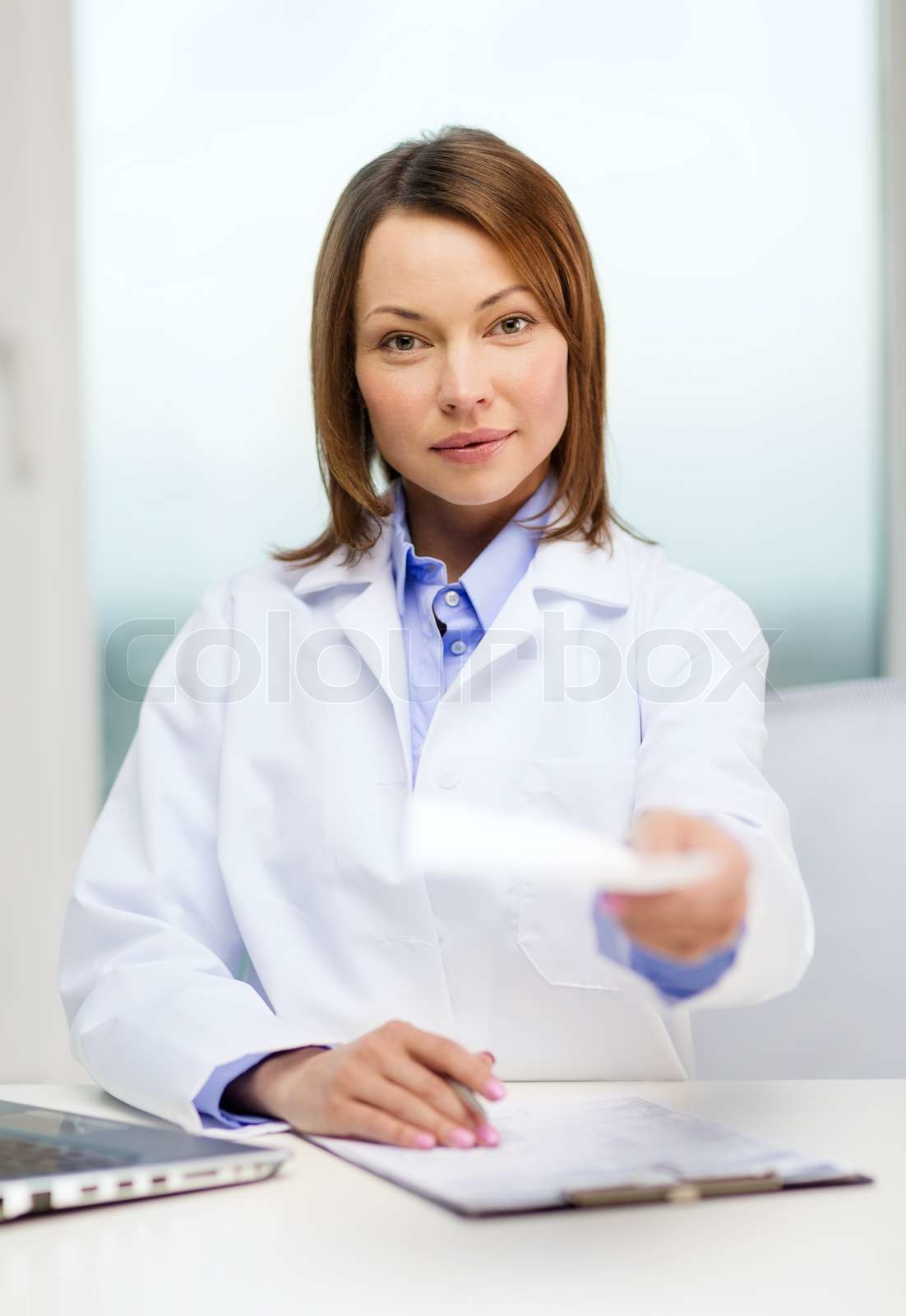 busy doctor with laptop computer and clipboard | Stock image | Colourbox