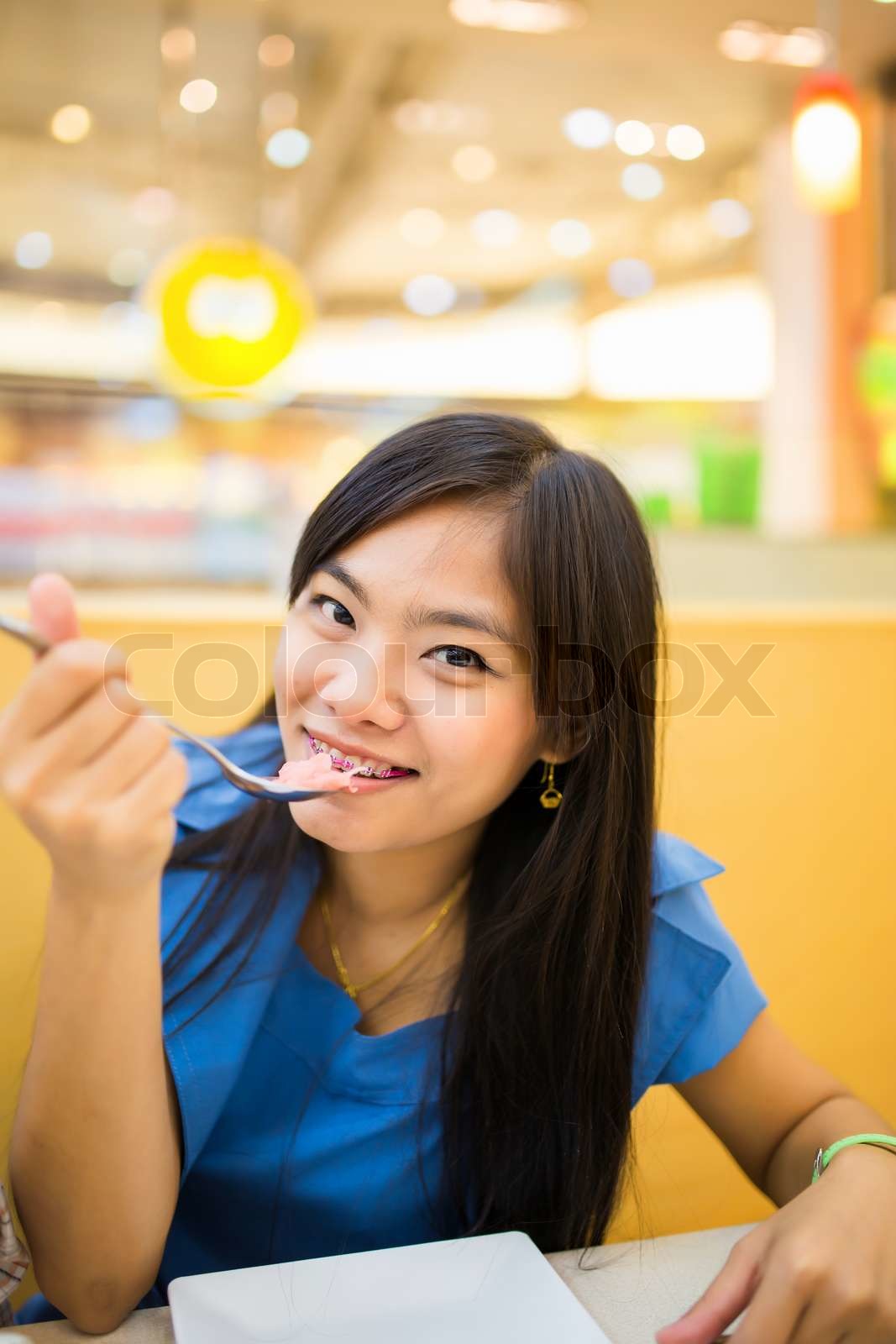 Beautiful Asian woman eating delicious food | Stock image | Colourbox