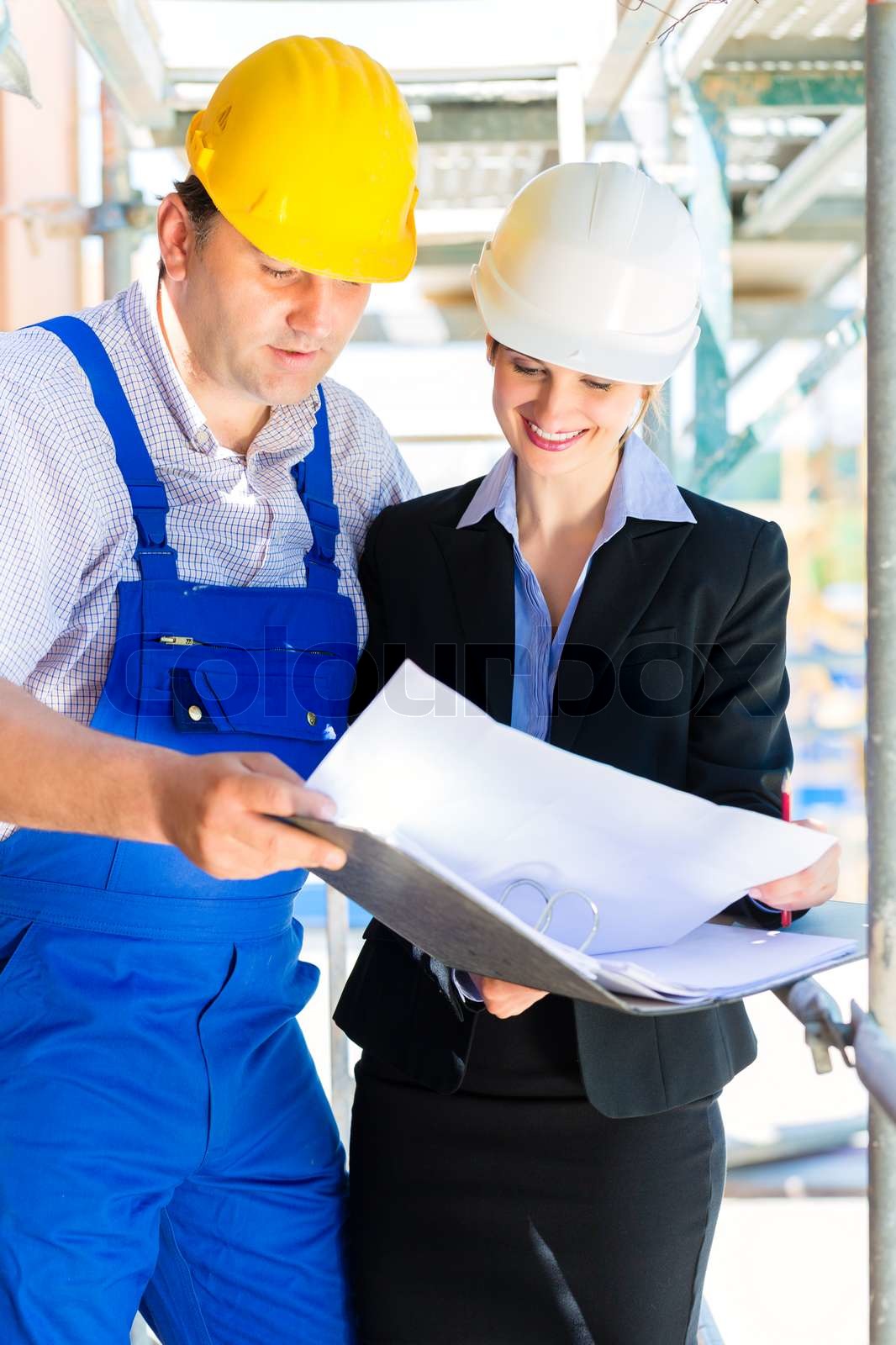 Construction Team with building plans on site | Stock image | Colourbox