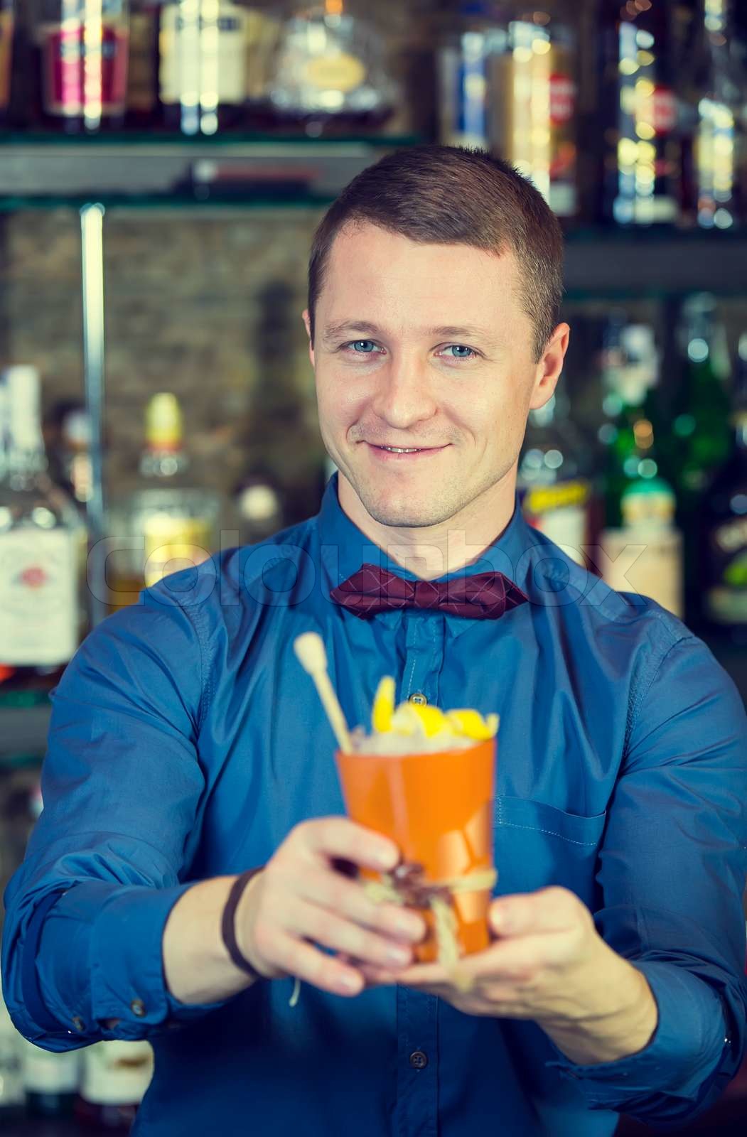 young man working as a bartender in a nightclub bar | Stock image ...