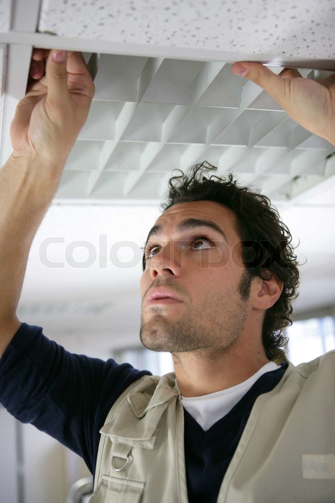 Man putting up a suspended ceiling | Stock image | Colourbox