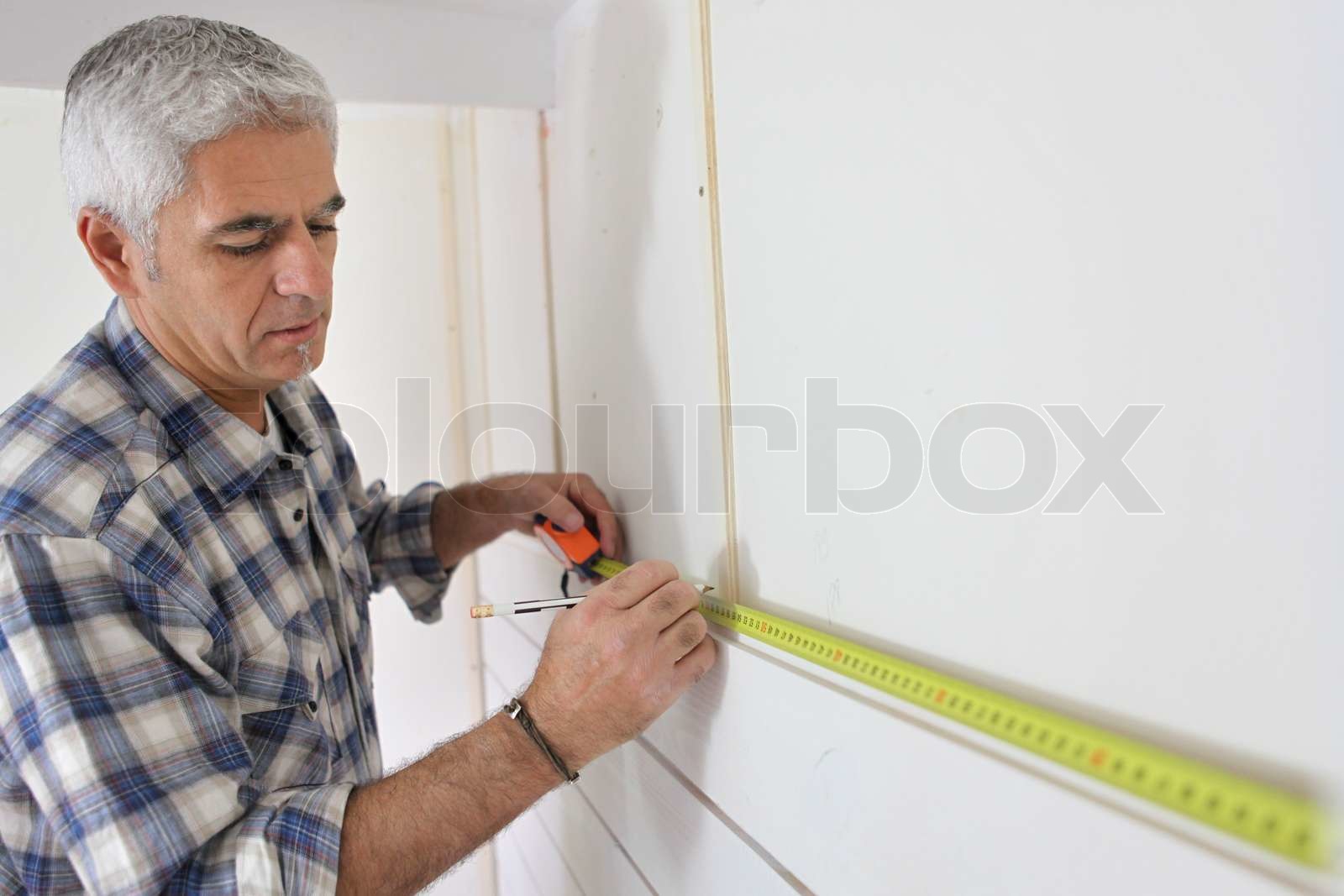 Man measuring wall | Stock image | Colourbox