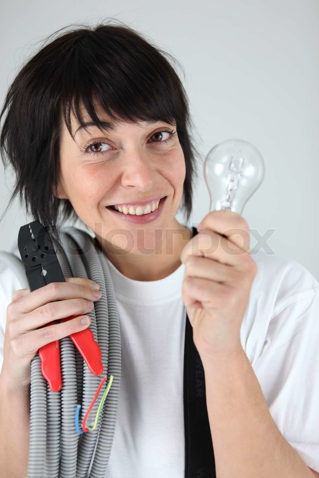 Female electrician holding replacement wiring and bulb | Stock image ...