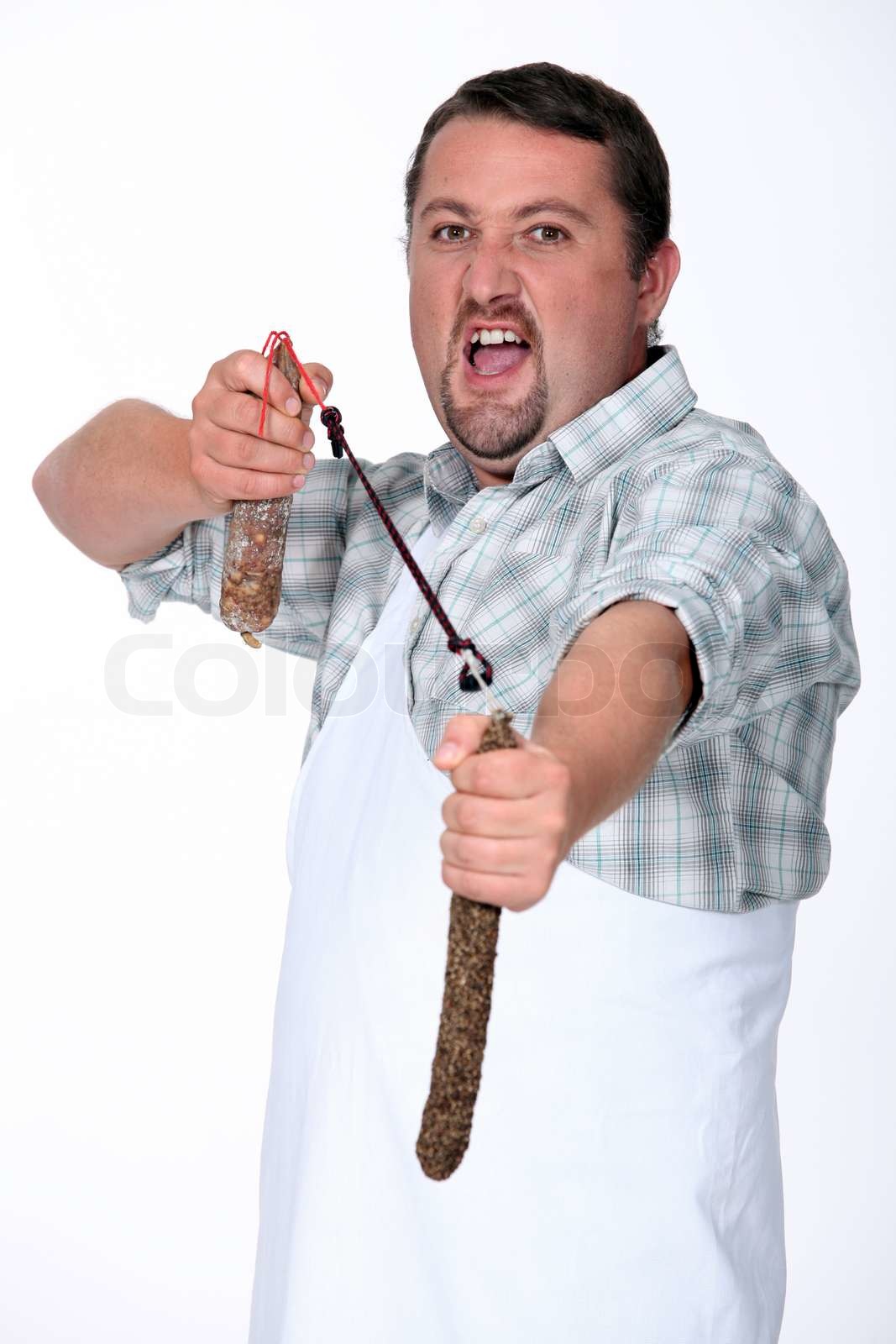 Angry butcher fighting with sausages | Stock image | Colourbox
