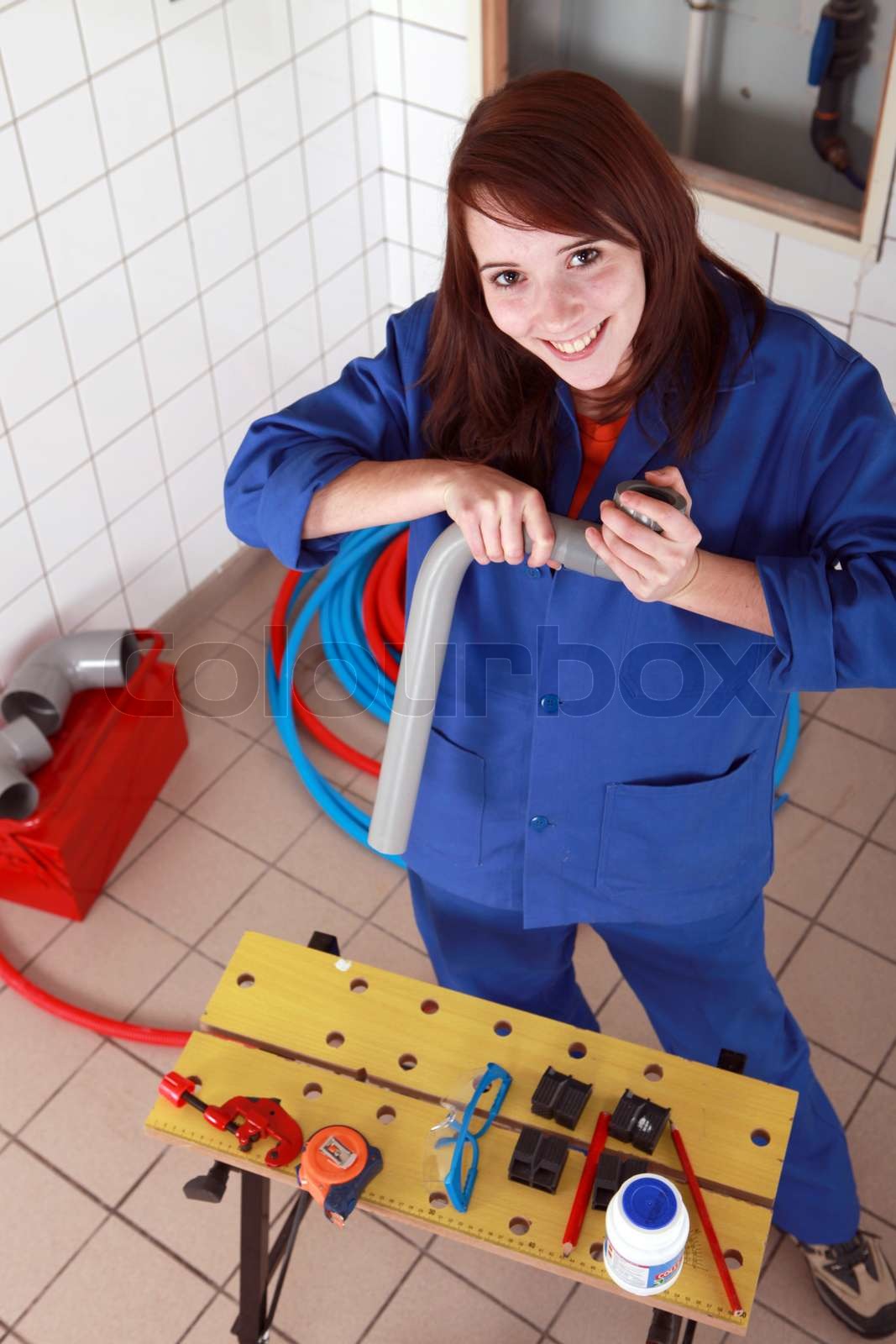 Female plumber with grey plastic pipe and tools | Stock image | Colourbox