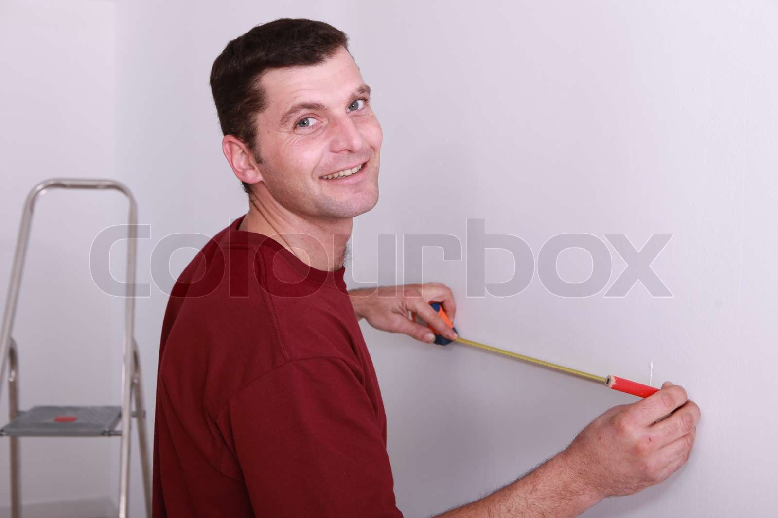 Man measuring wall | Stock image | Colourbox