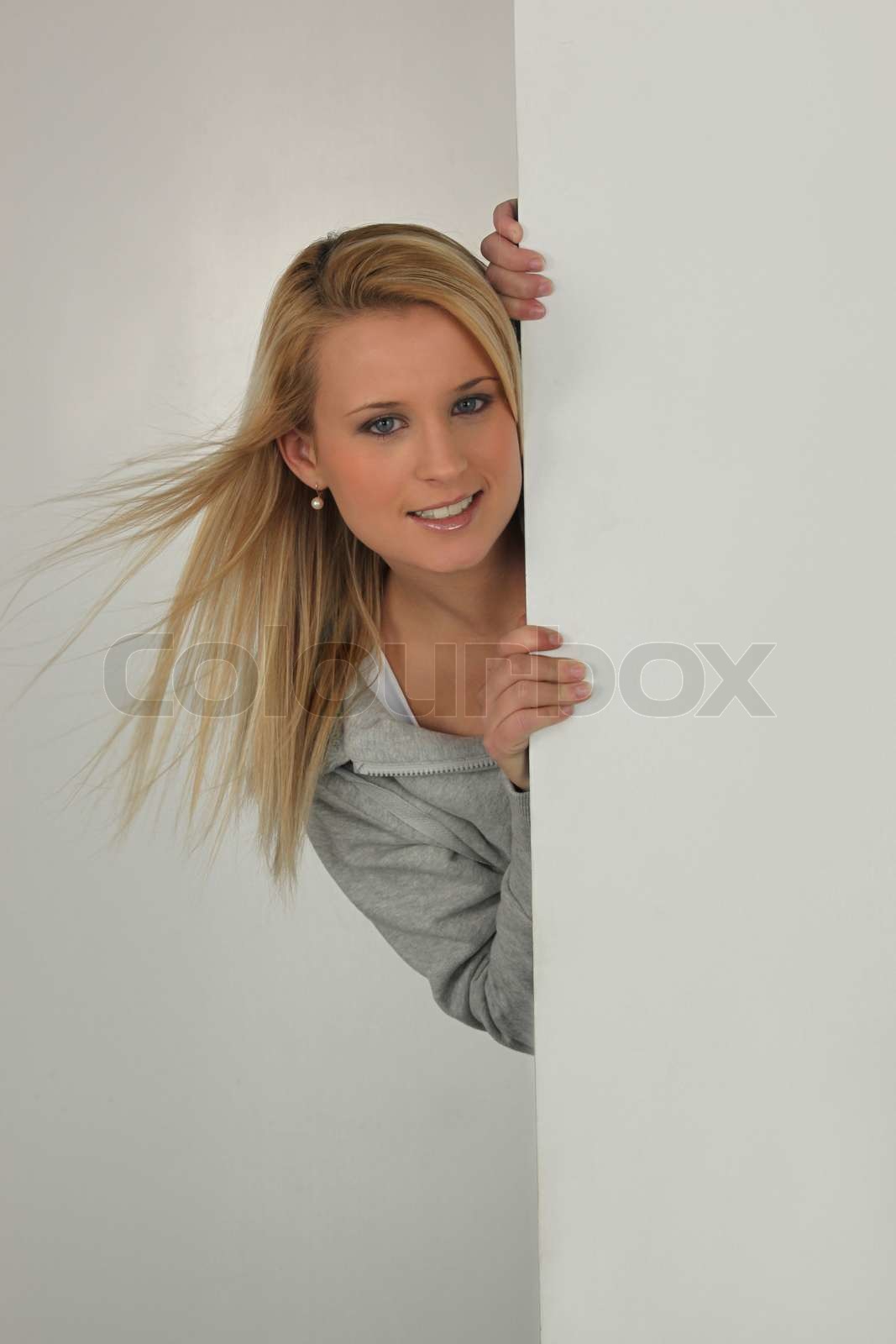 Woman sticking out behind the wall | Stock image | Colourbox