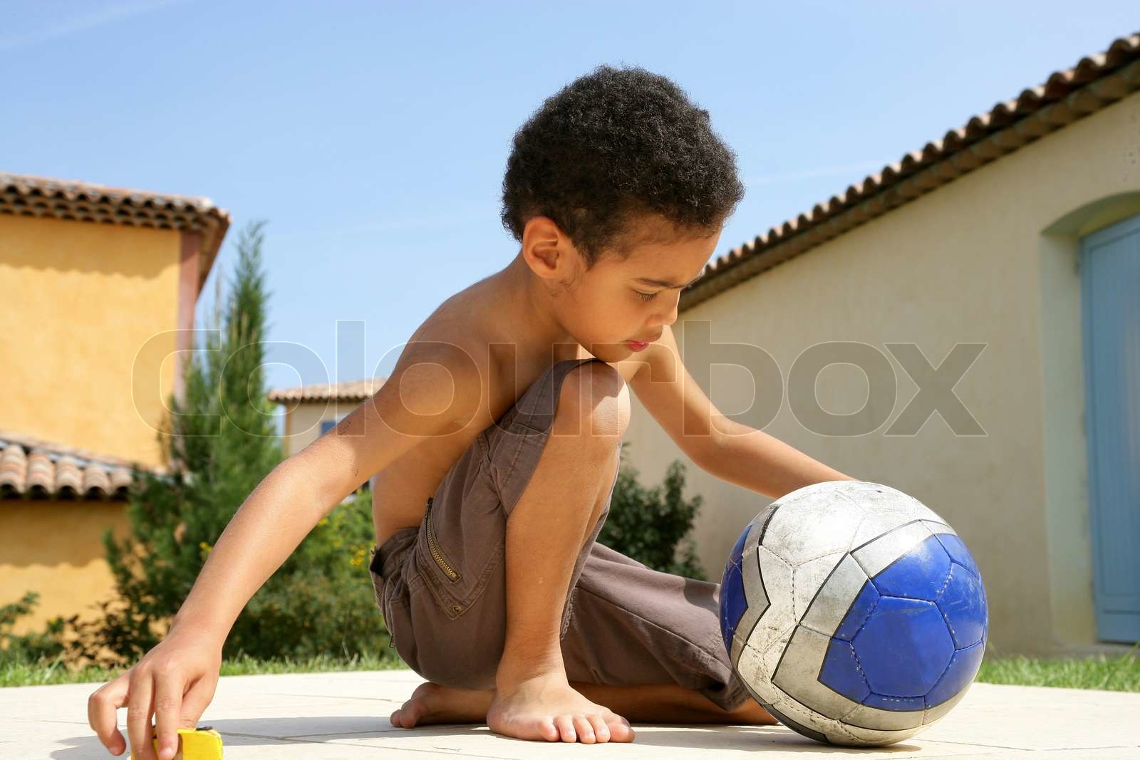 kleiner Junge sitzt mit einem ball | Stock Bild | Colourbox