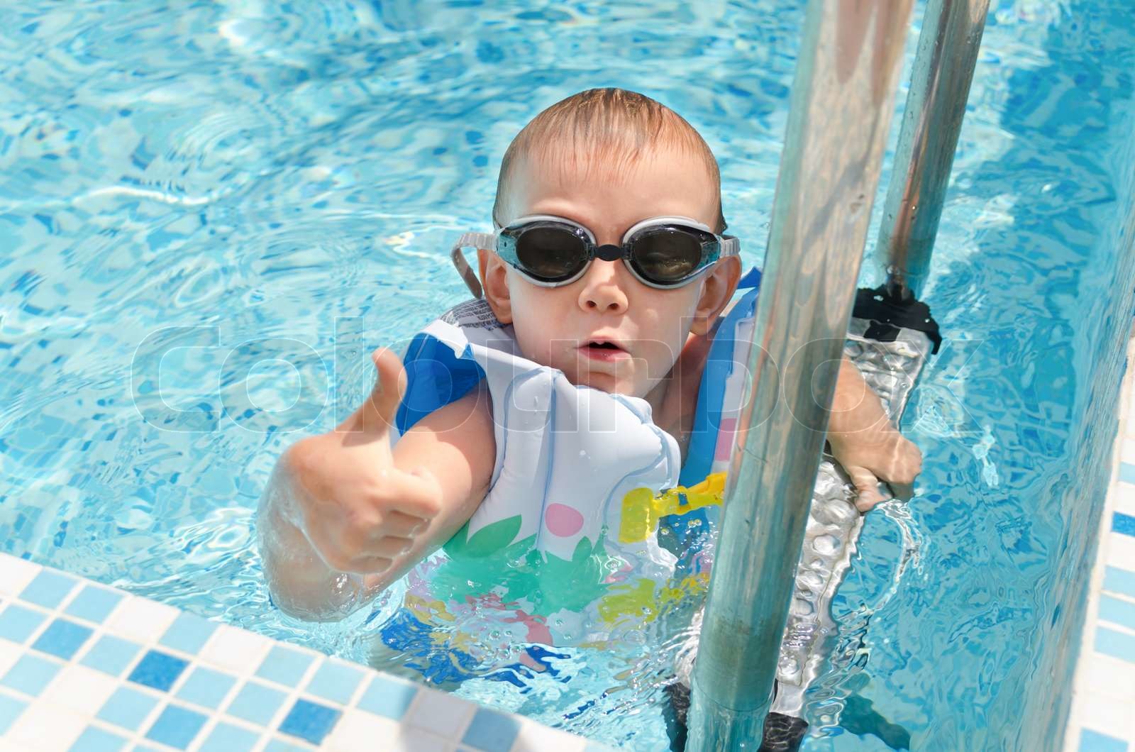 Young boy in a swimming pool giving a thumbs up | Stock image | Colourbox