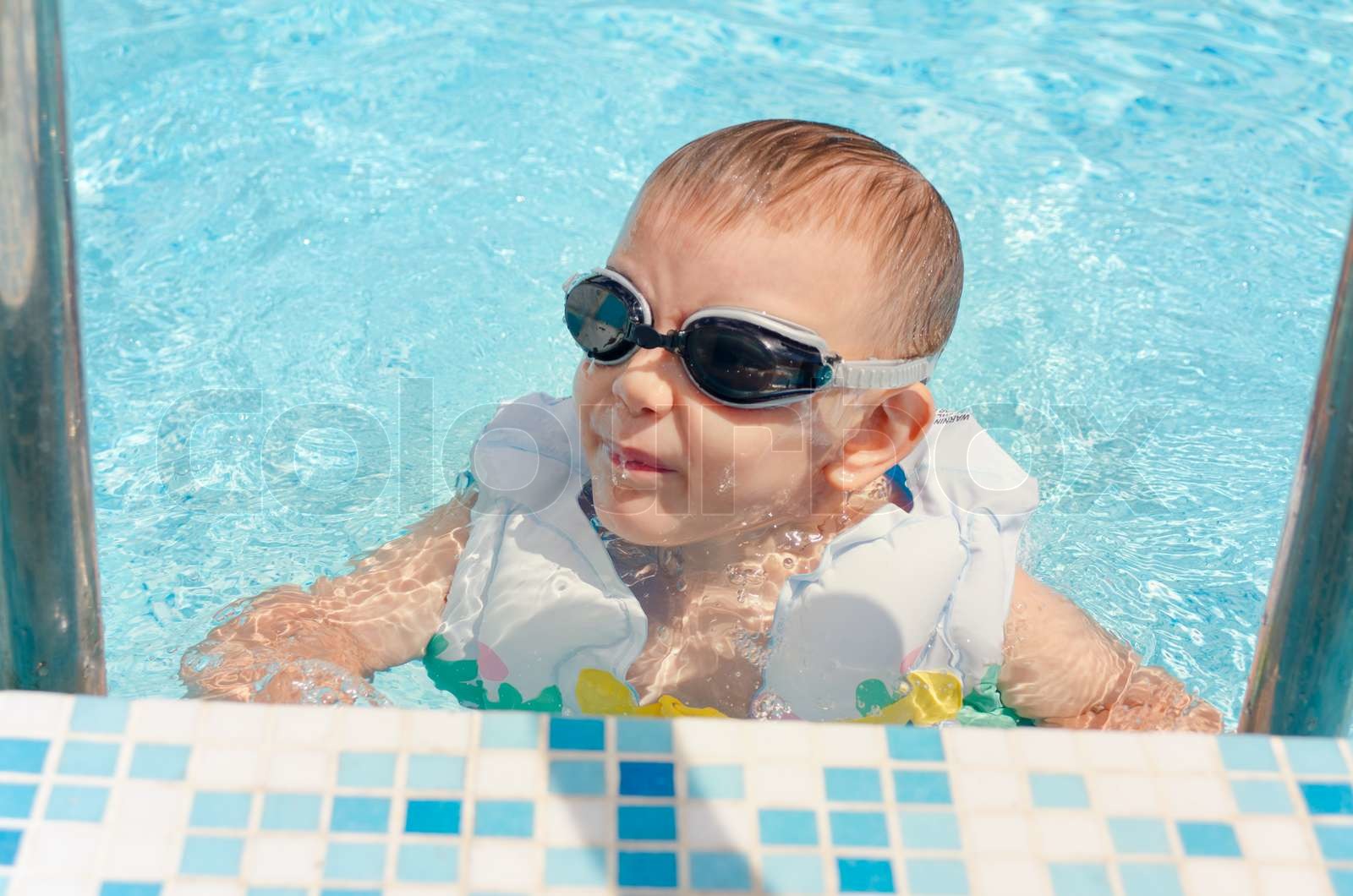 Laughing little boy climbing out of a pool | Stock image | Colourbox