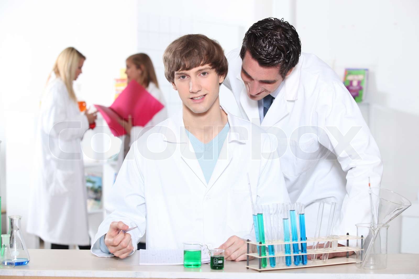 Teacher checking students work in laboratory | Stock image | Colourbox