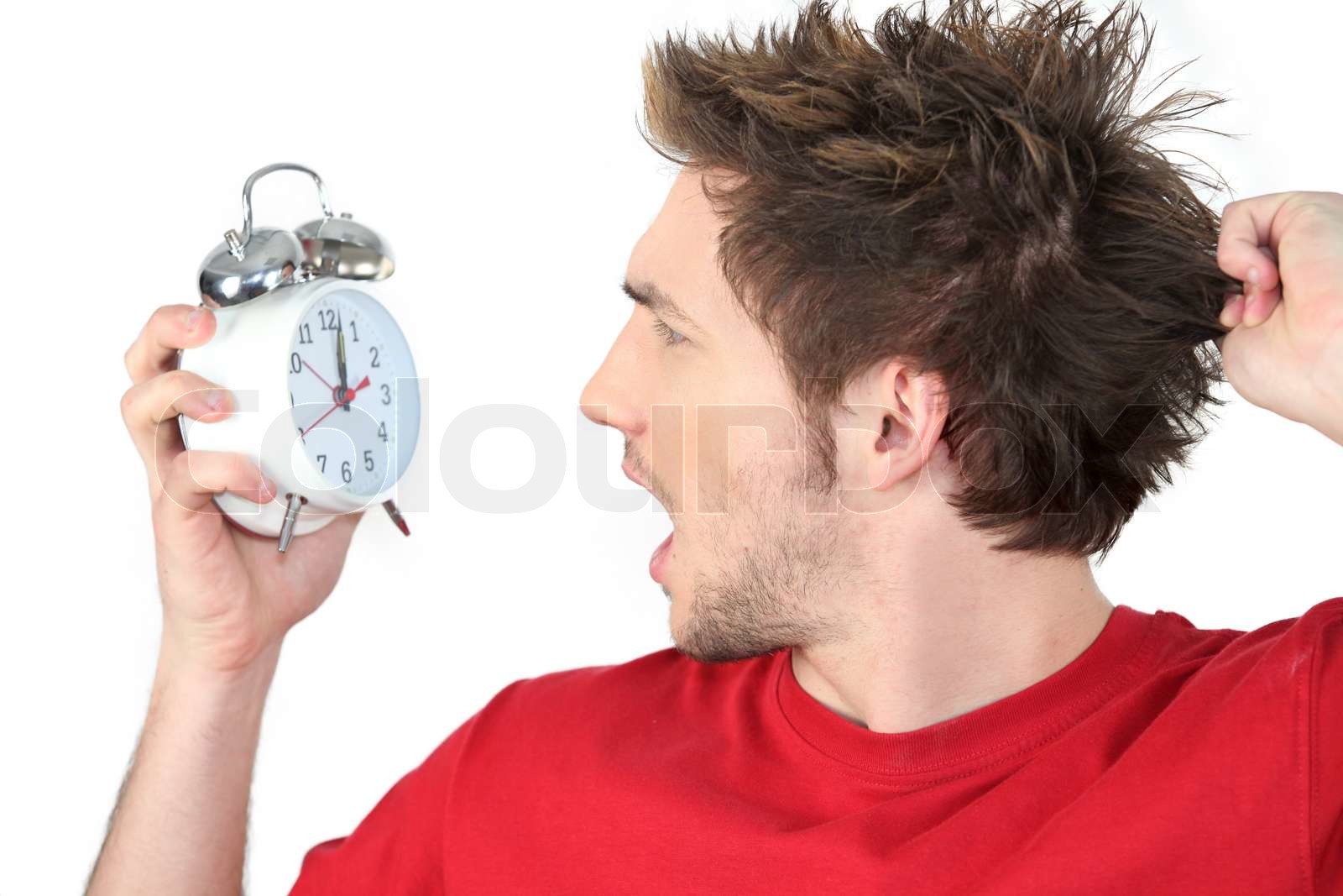Man screaming with alarm clock in hand | Stock image | Colourbox