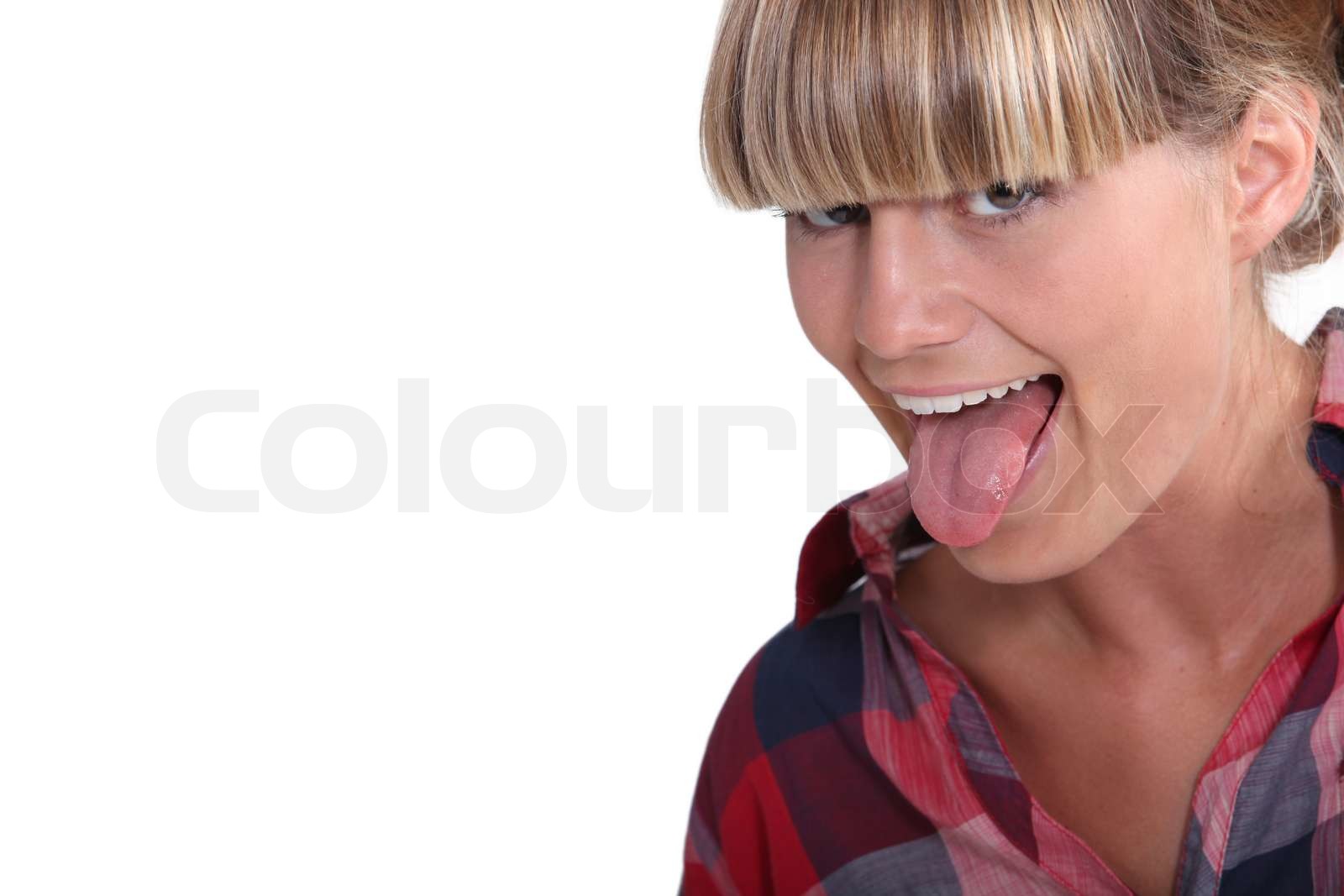A blond teenager pulling her tongue out. | Stock image | Colourbox